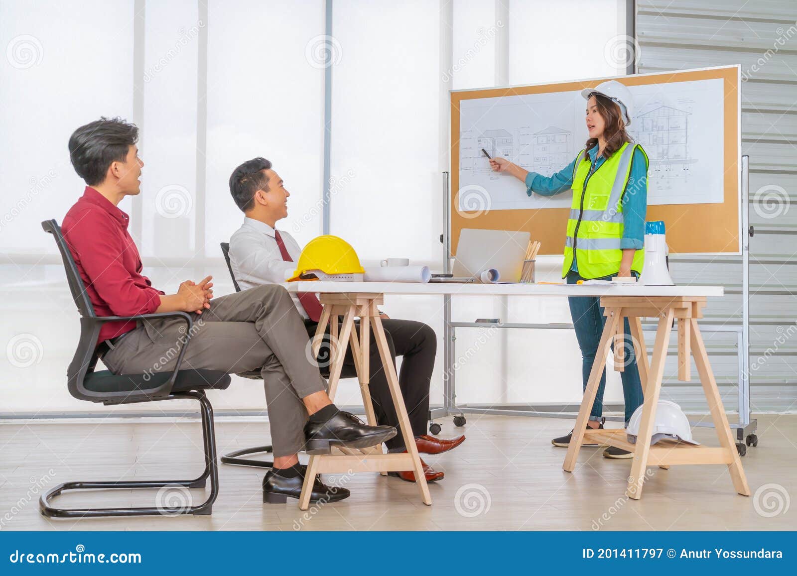 Female Engineer Presenting Building Plan Drawing To Her Contractor Team ...