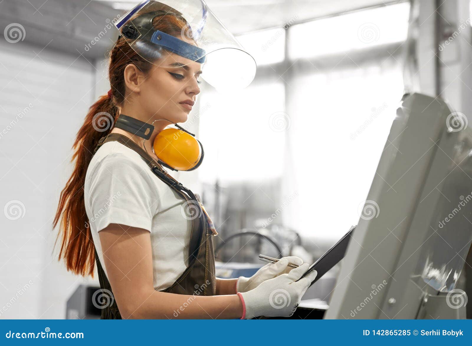 Female Engineer in Protective Clothes Working on Factory. Stock Image ...