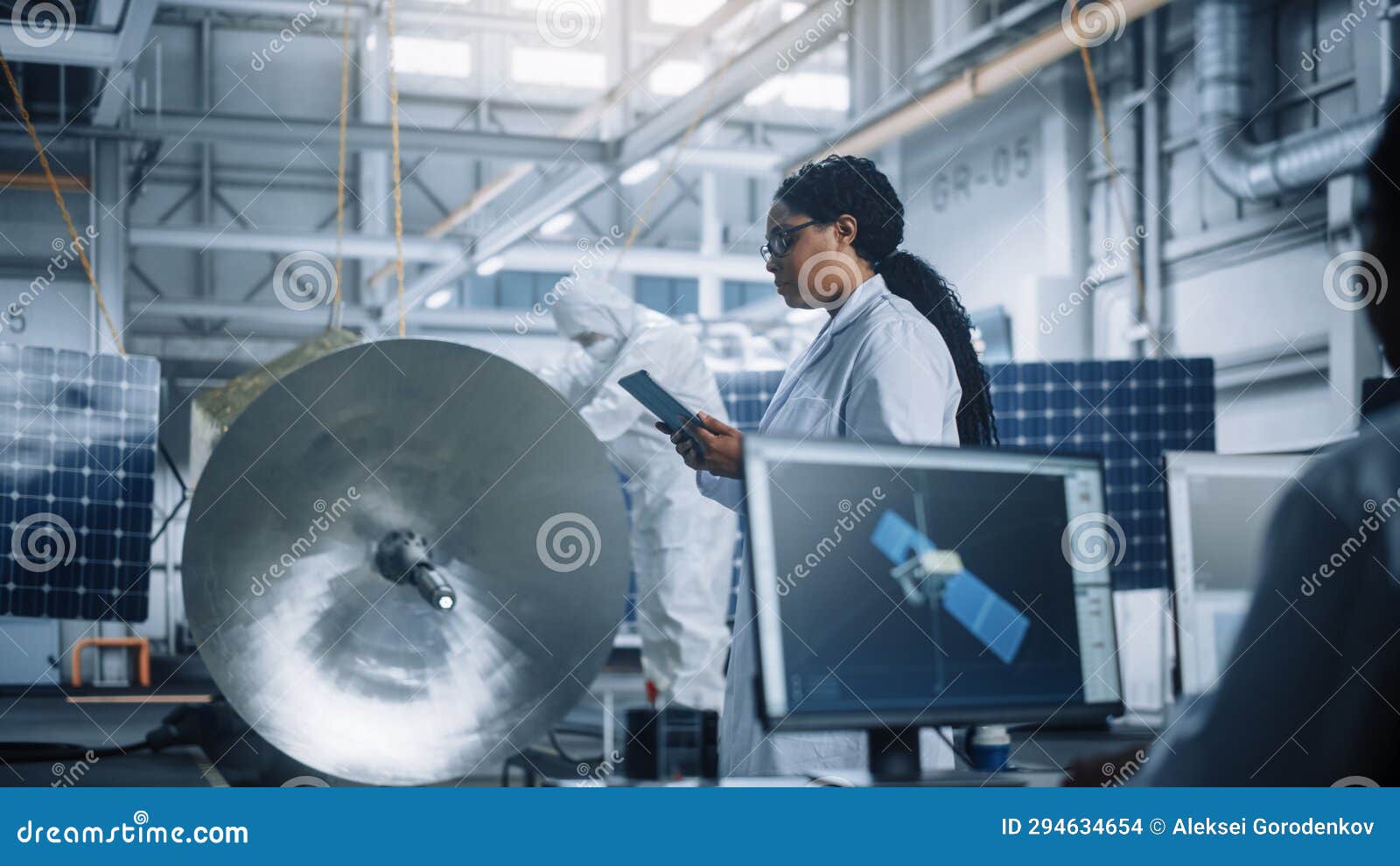 Female Engineer Uses Tablet Computer while Working on Satellite ...