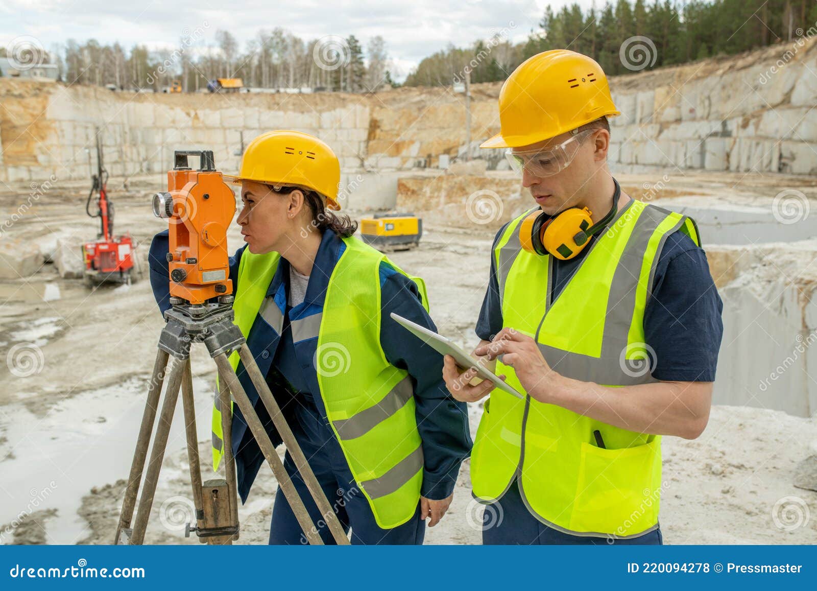 Female Engineer Using Geodetic Station by Her Colleague Stock Photo ...