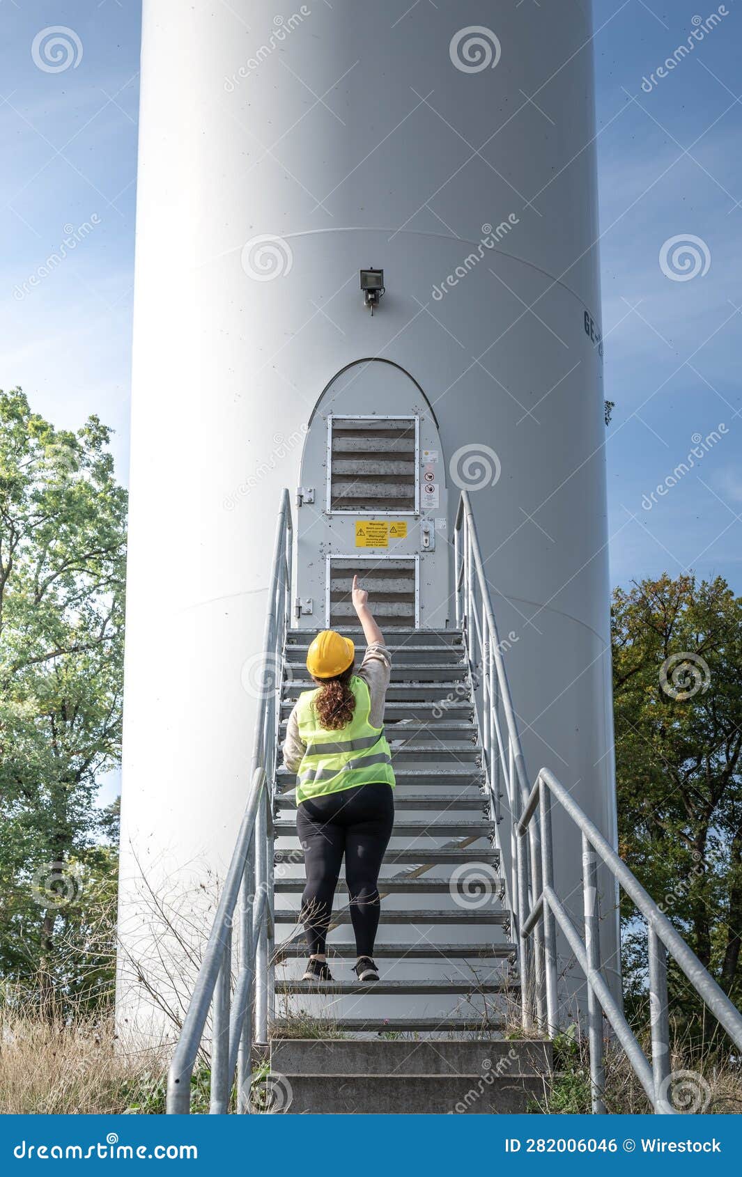 Female Engineer Walking Up the Stair of a Tall, White Windmill Stock ...