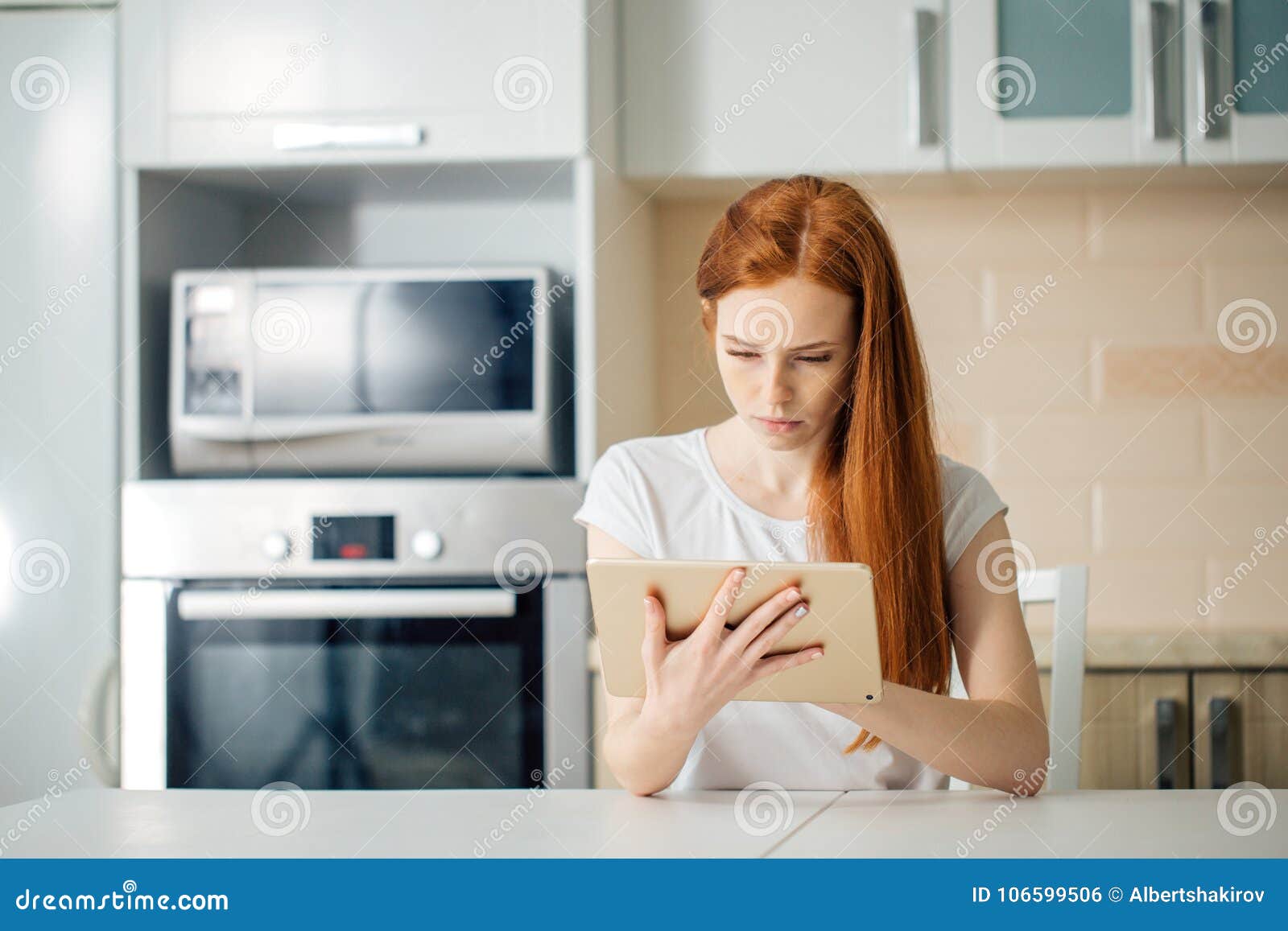 Female Entrepreneur Thinking while Working at Table in Her Kitchen at ...