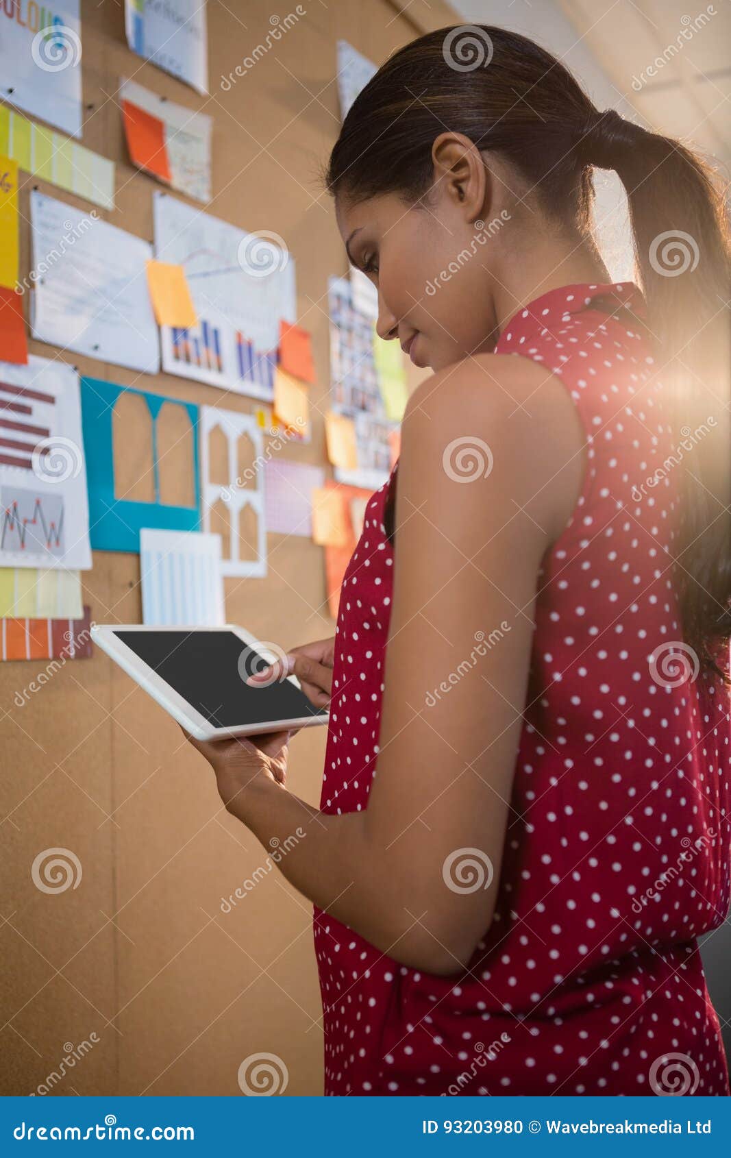 Female Executive Using Digital Tablet Near Bulletin Board Stock Photo ...