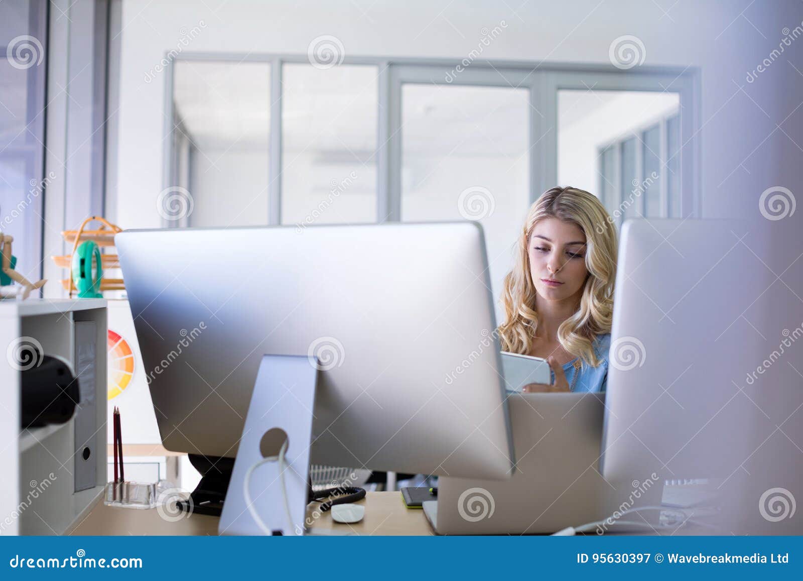 Female Executive Using Mobile Phone while Working at Her Desk Stock ...