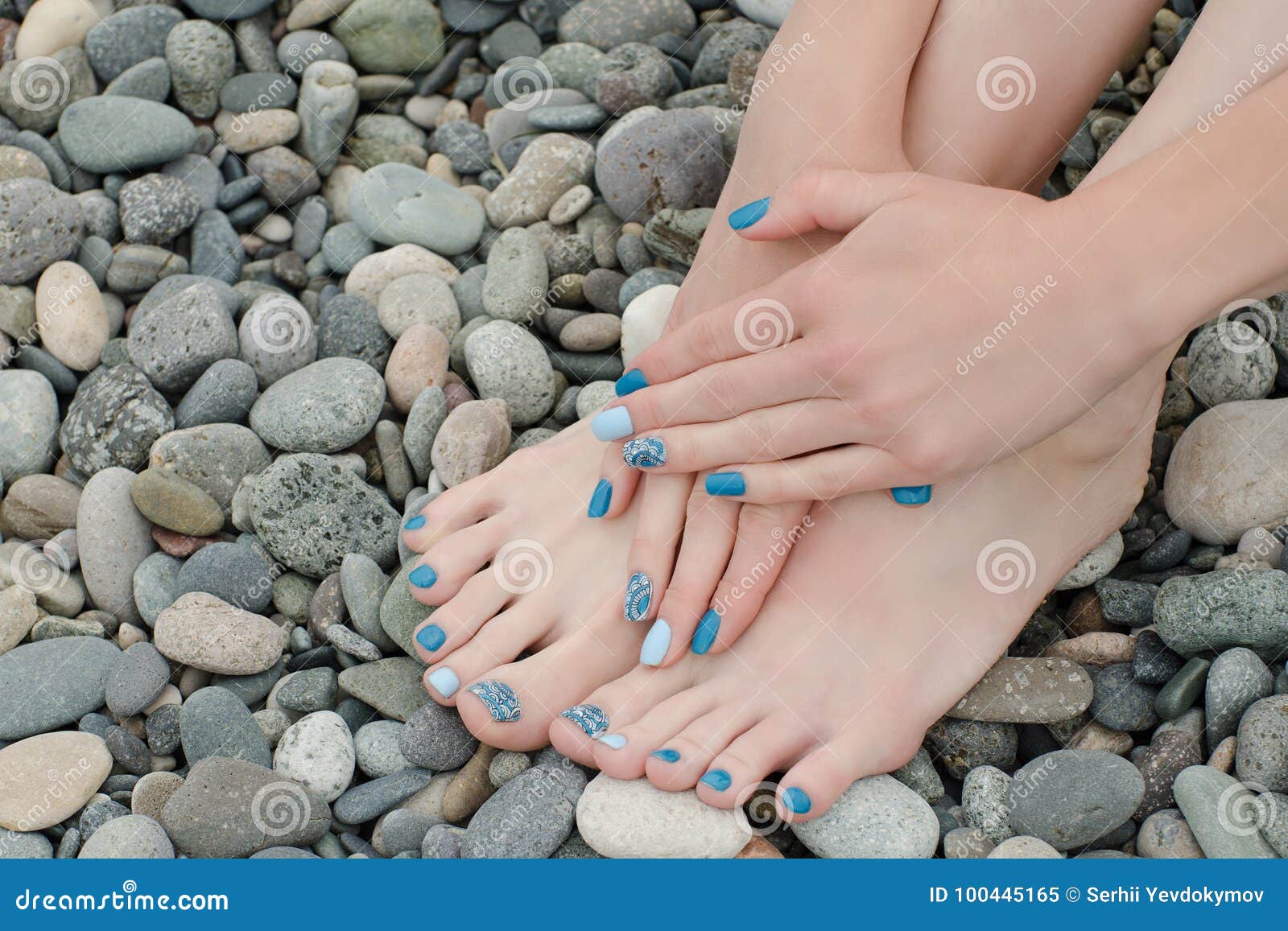 Female Feet and Hands with a Blue Manicure on Pebbles Stock Image ...