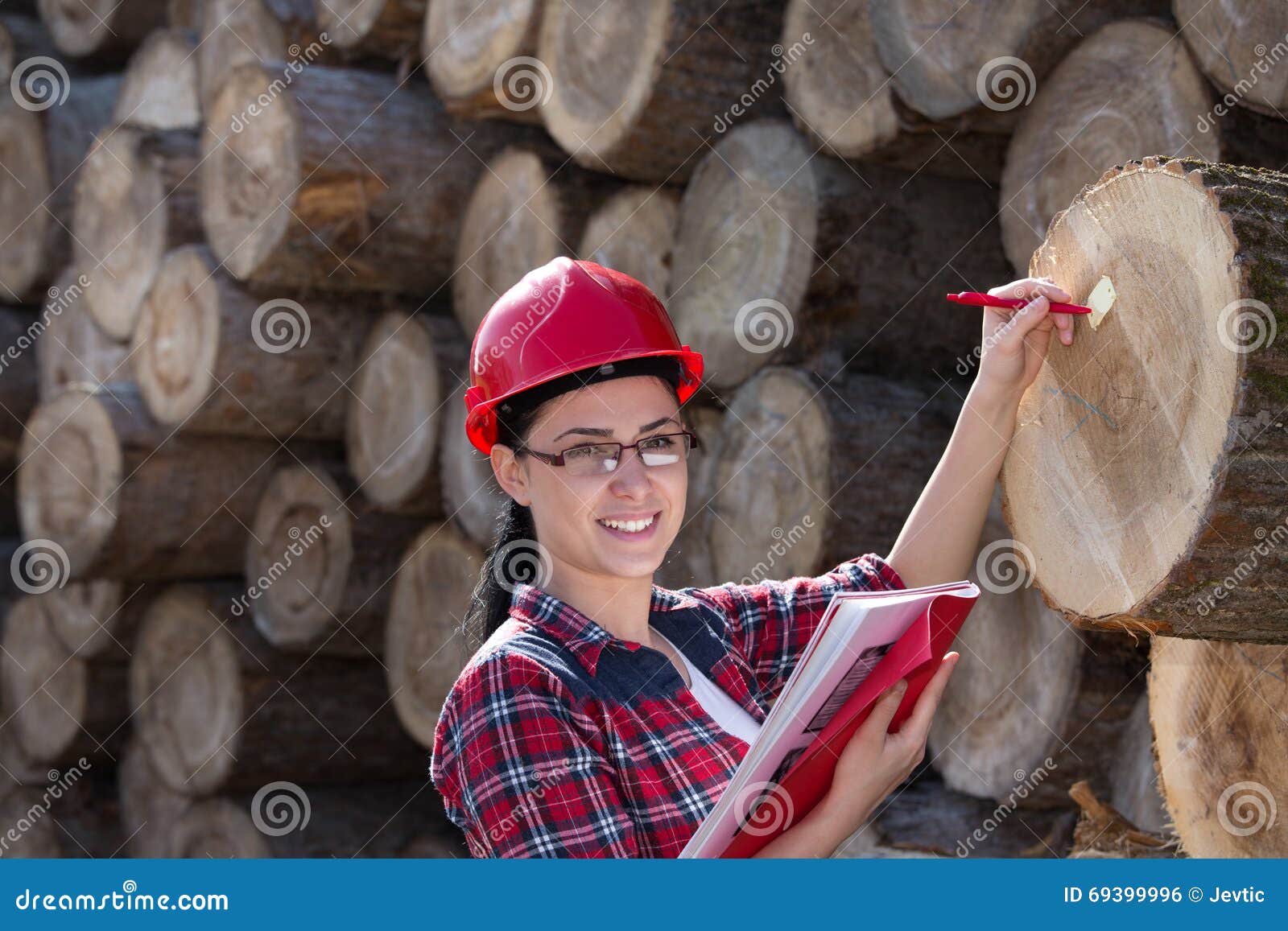 Female Forest Engineer beside Logs Stock Photo - Image of note ...
