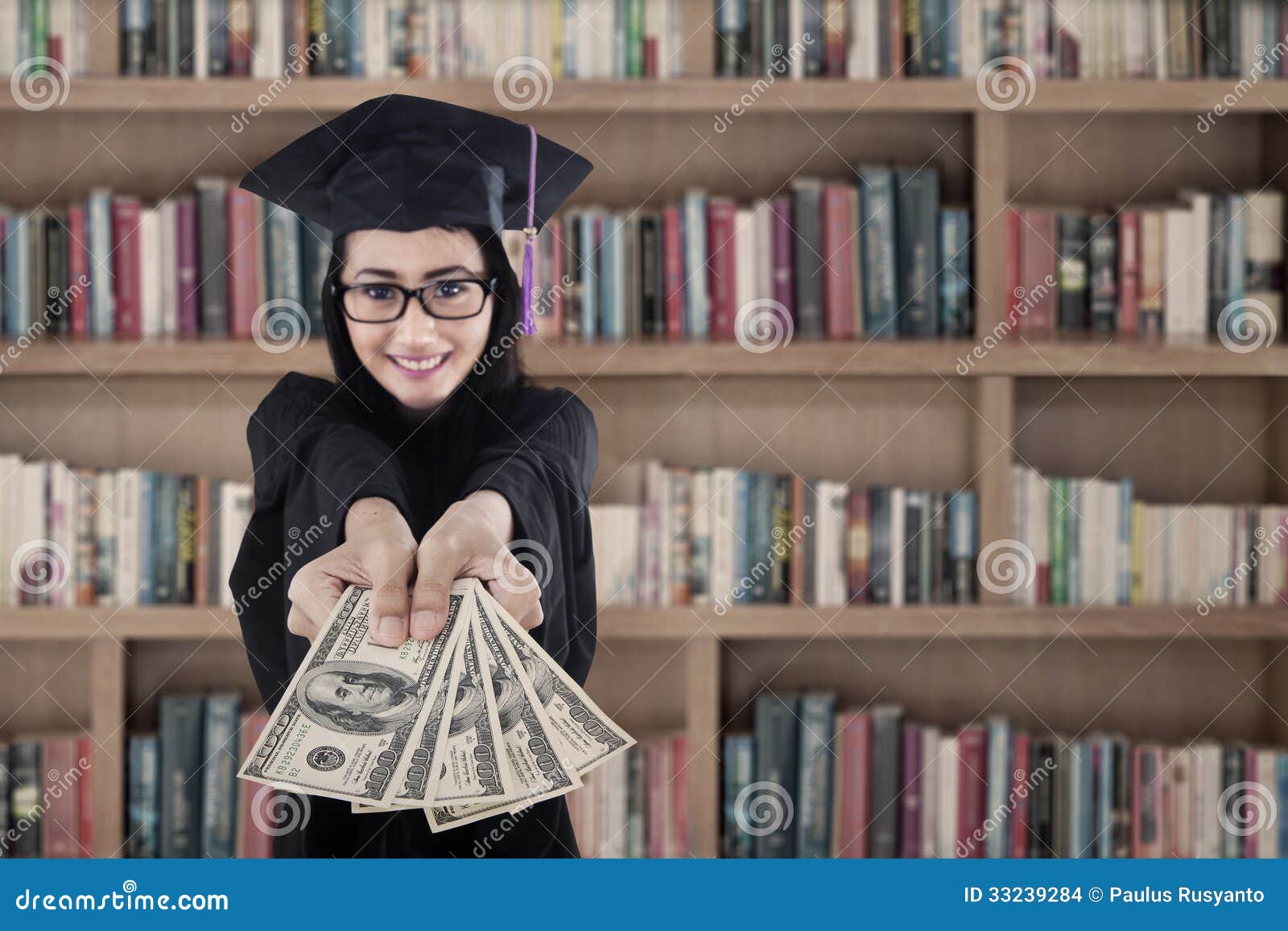Female Graduate Holding Money at Library Stock Photo - Image of ...