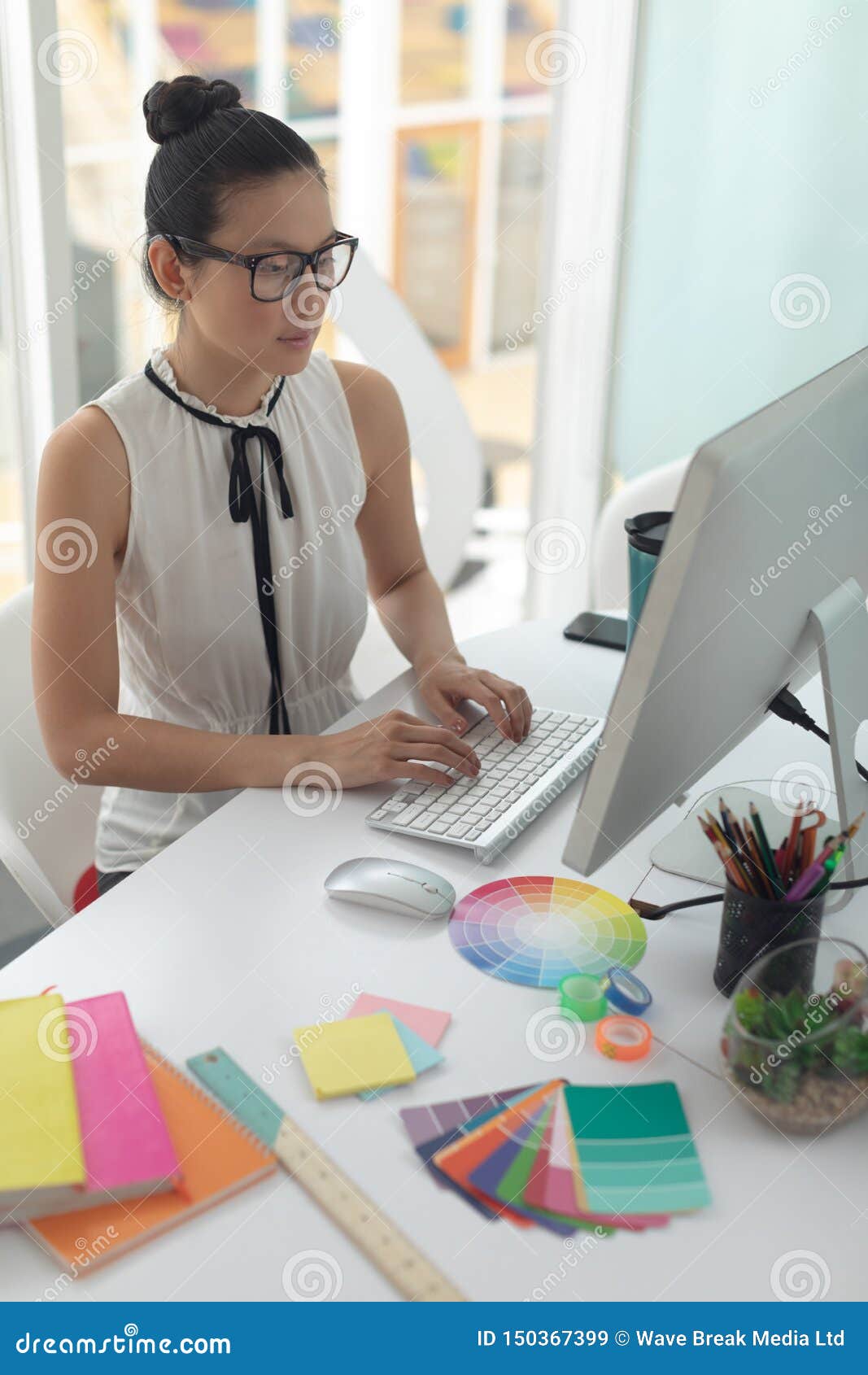 Female Graphic Designer Working on Computer at Desk in a Modern Office ...