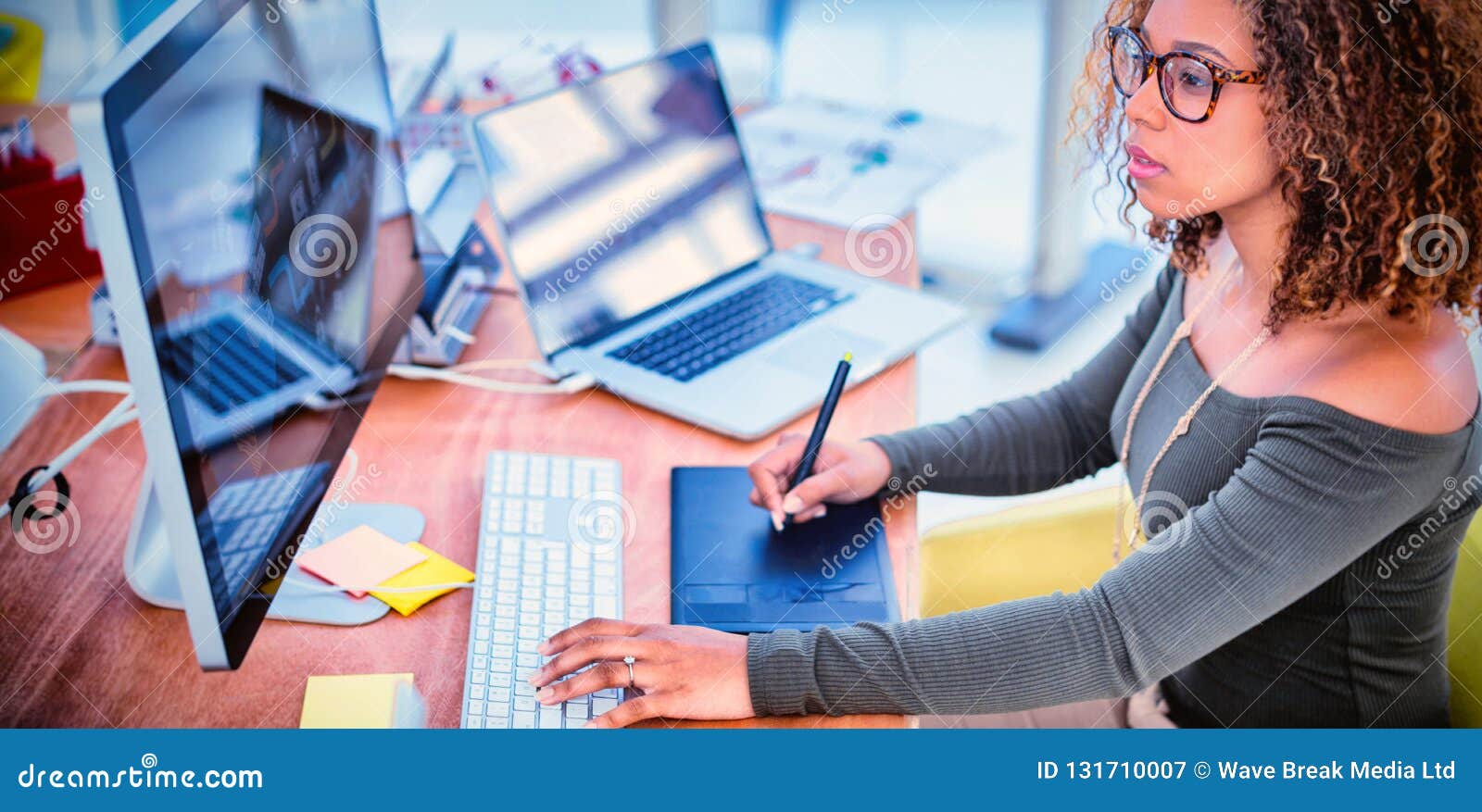 Female Graphic Designer Working on Computer while Using Graphic Tablet ... Female Graphic Designer Working on Computer while Using Graphic Tablet ...