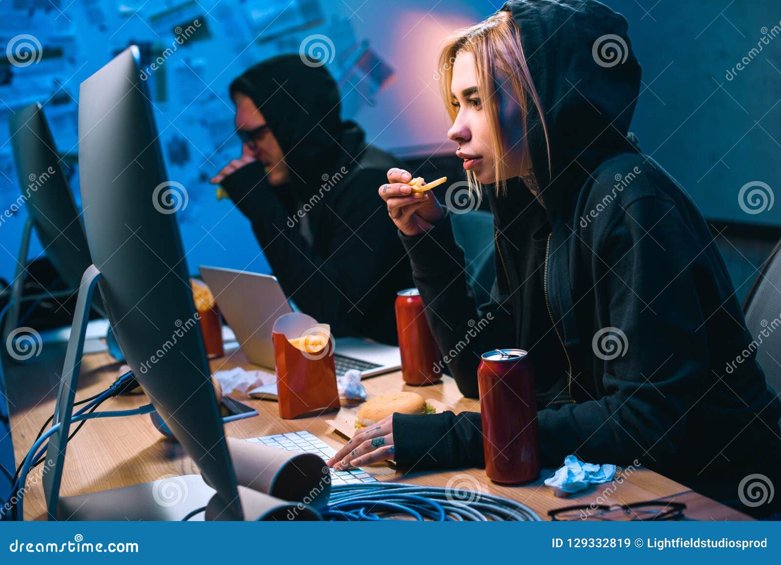 Female Hacker Working on Malware with Accomplice and Eating Stock Image ...