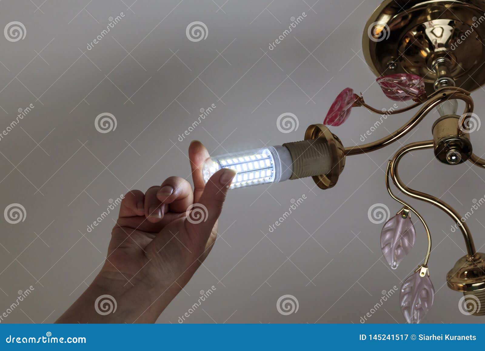 Female Hand Inserts a Light Bulb into the Threaded Socket. she is ...