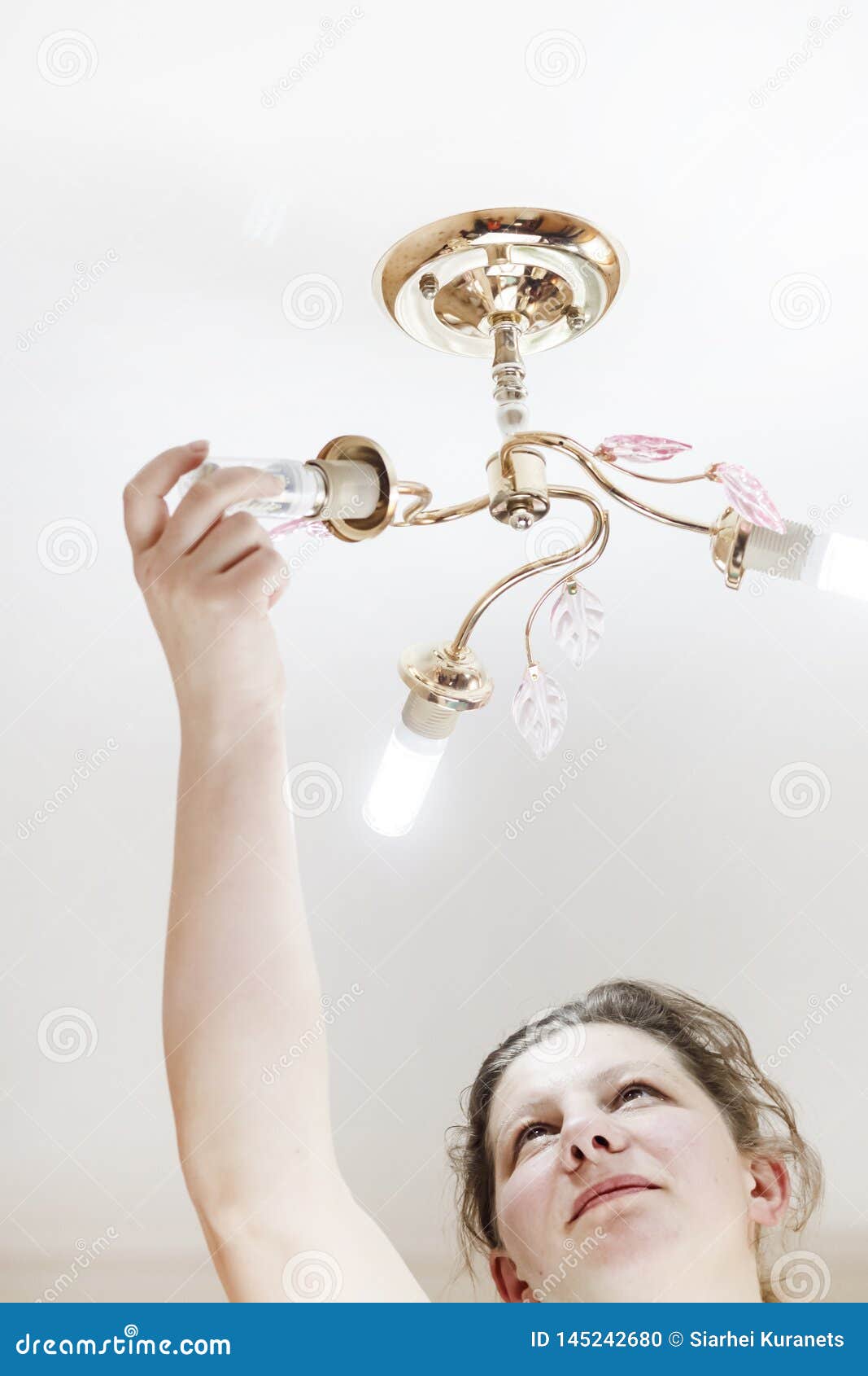 Female Hand Inserts a Light Bulb into the Threaded Socket. she is ...