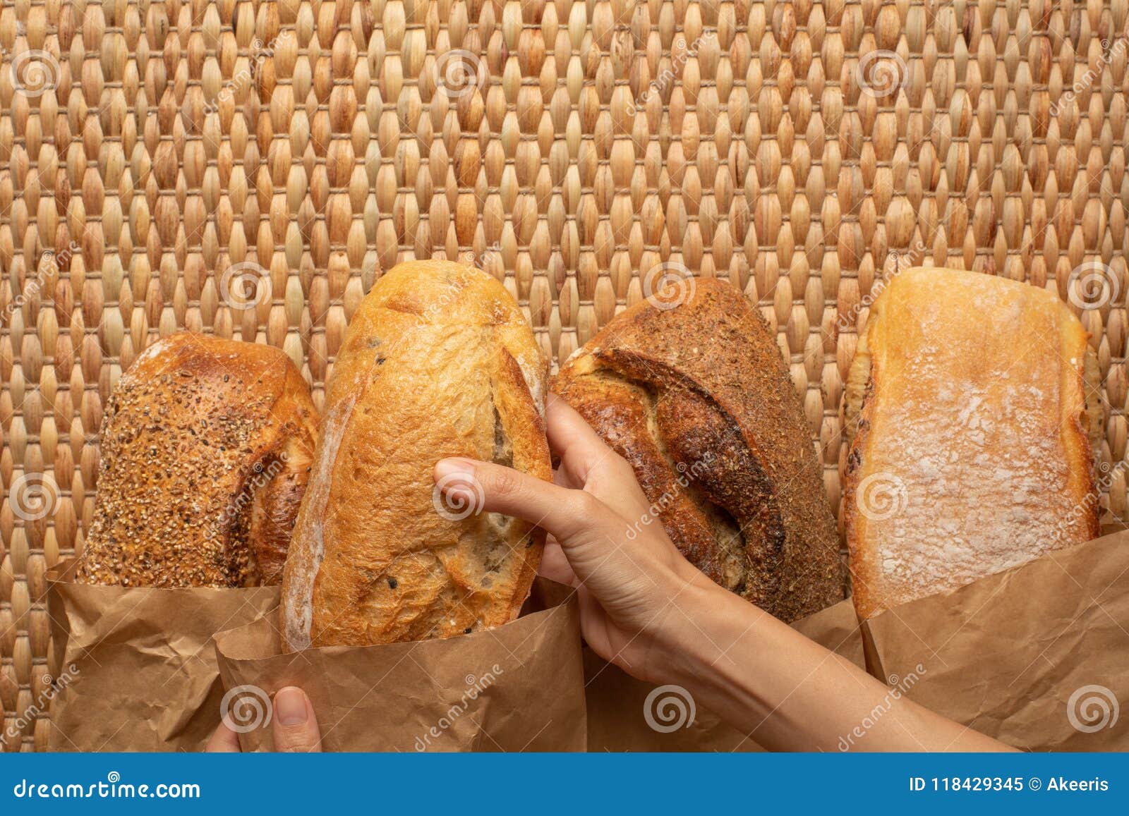 A Female Hand Picking a Loaf of Bread from Various Kind of Bread on ...