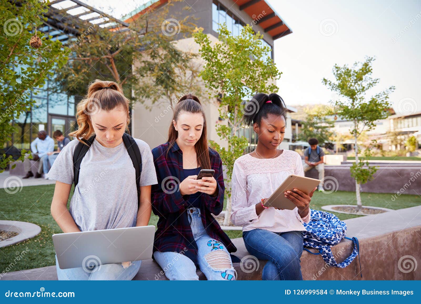 Female High School Students Using Digital Devices Outdoors during ...