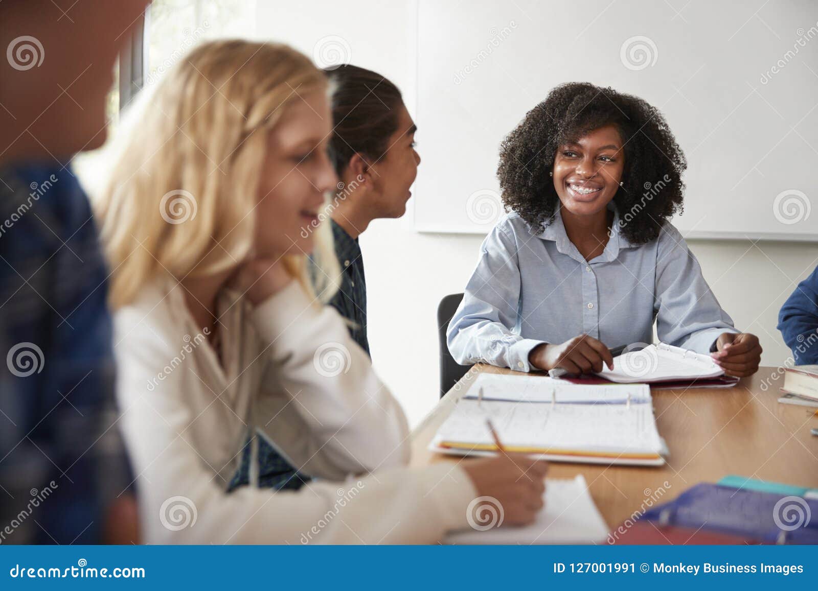 Female High School Tutor Sitting at Table with Pupils Teaching Maths ...