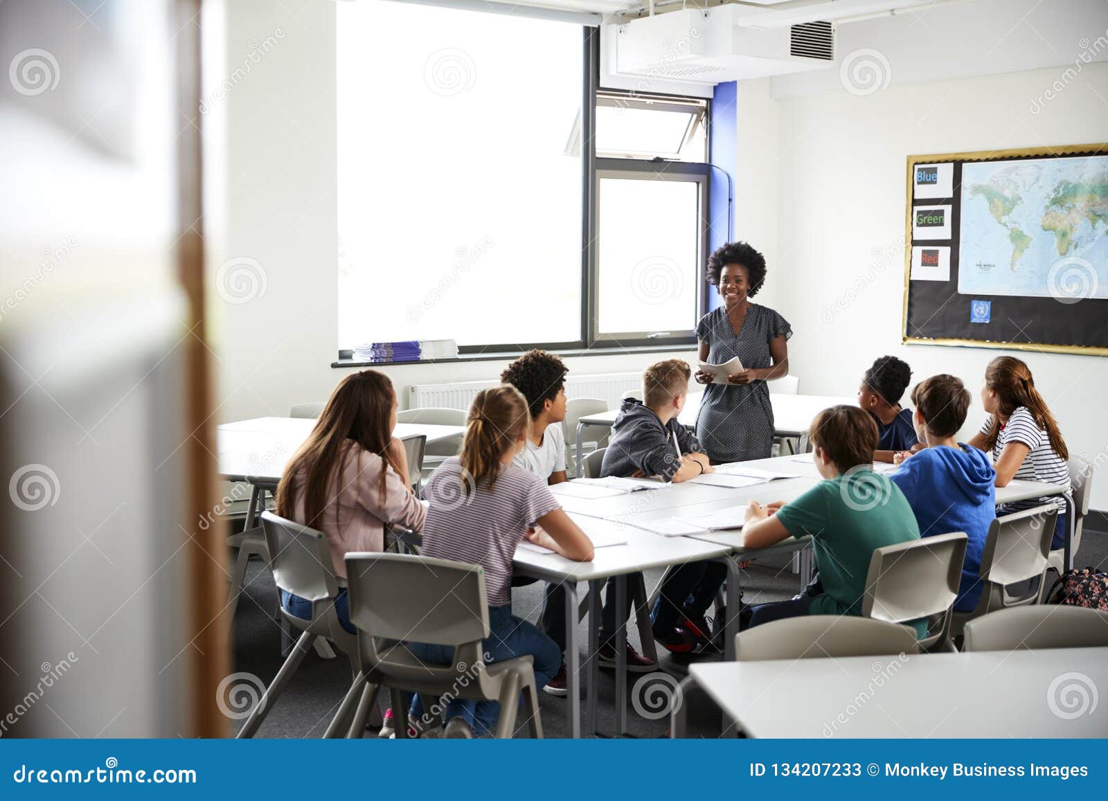 Female High School Tutor Standing by Table with Students Teaching ...