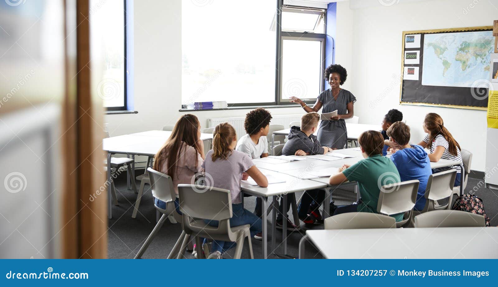 Female High School Tutor Standing by Table with Students Teaching ...