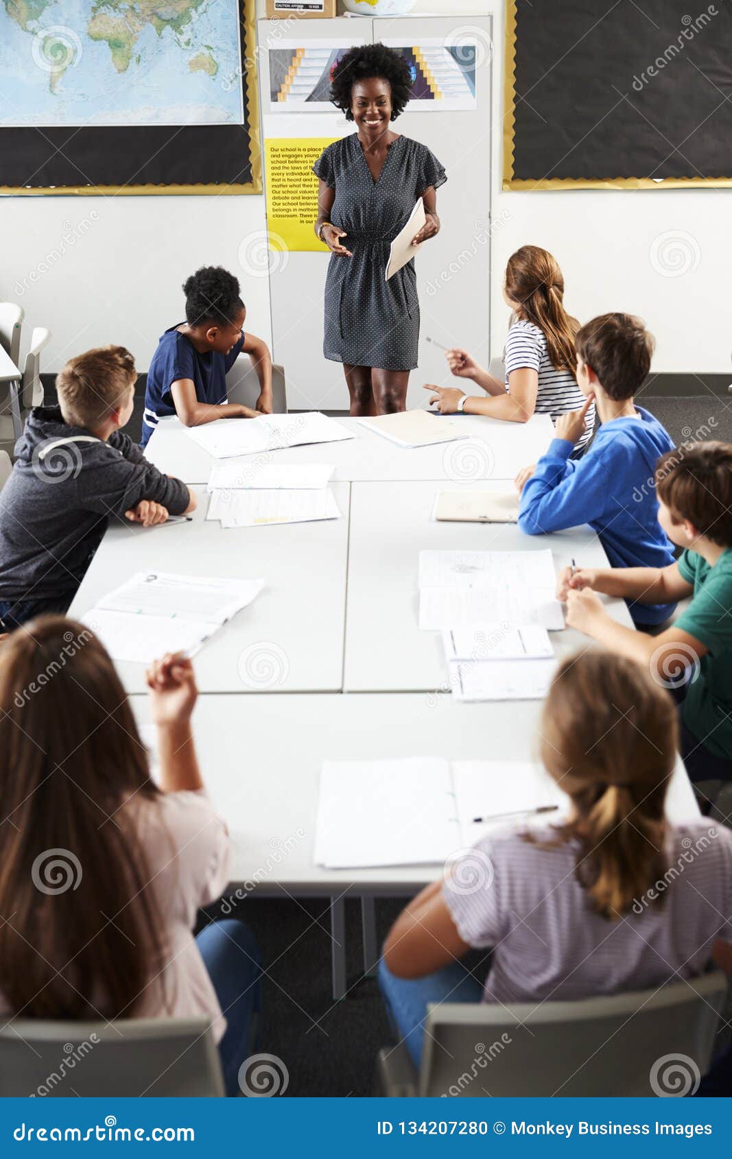 Female High School Tutor Standing by Table with Students Teaching ...