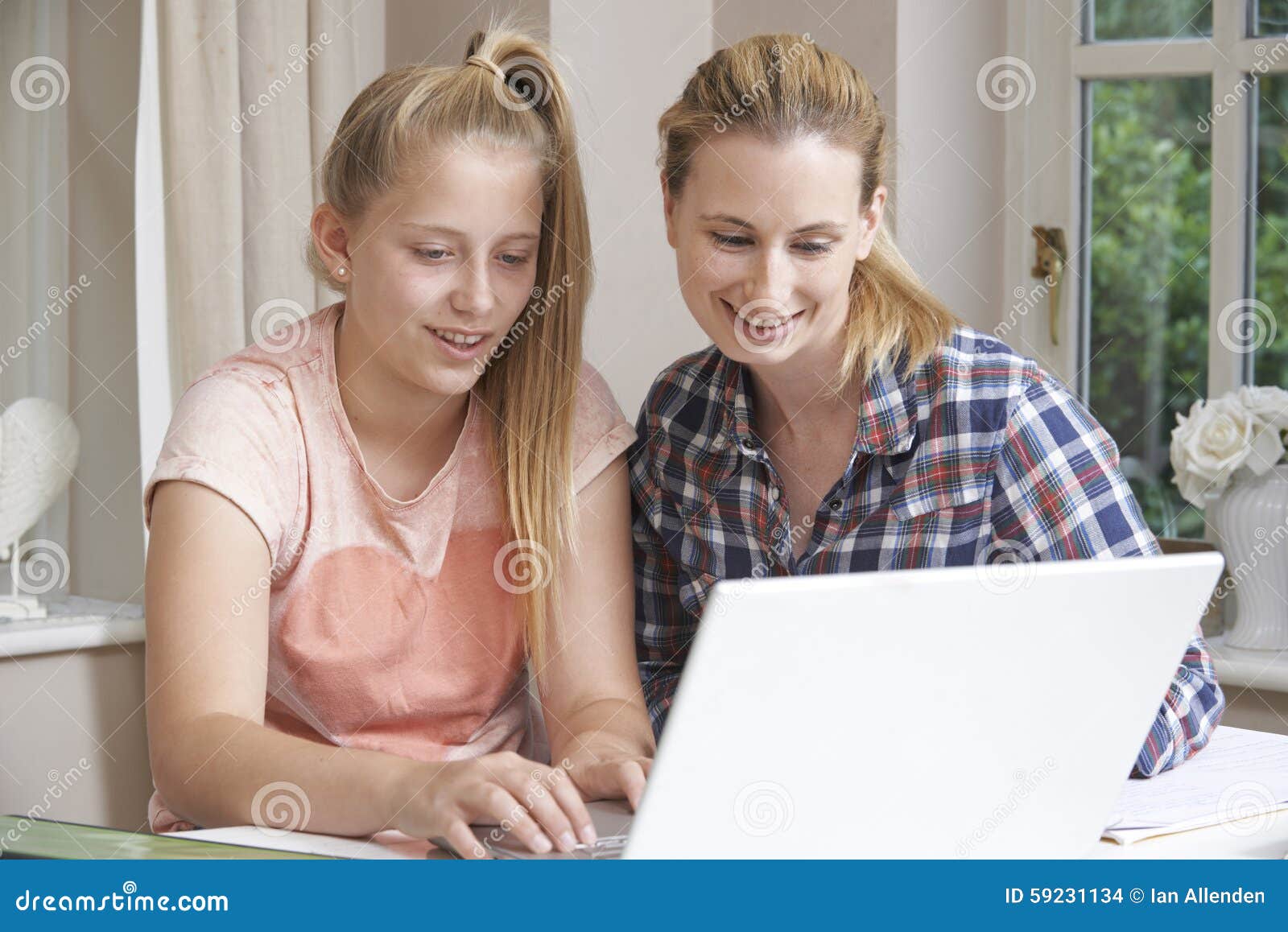 Female Home Tutor Helping Girl with Studies Using Laptop Stock Photo ...