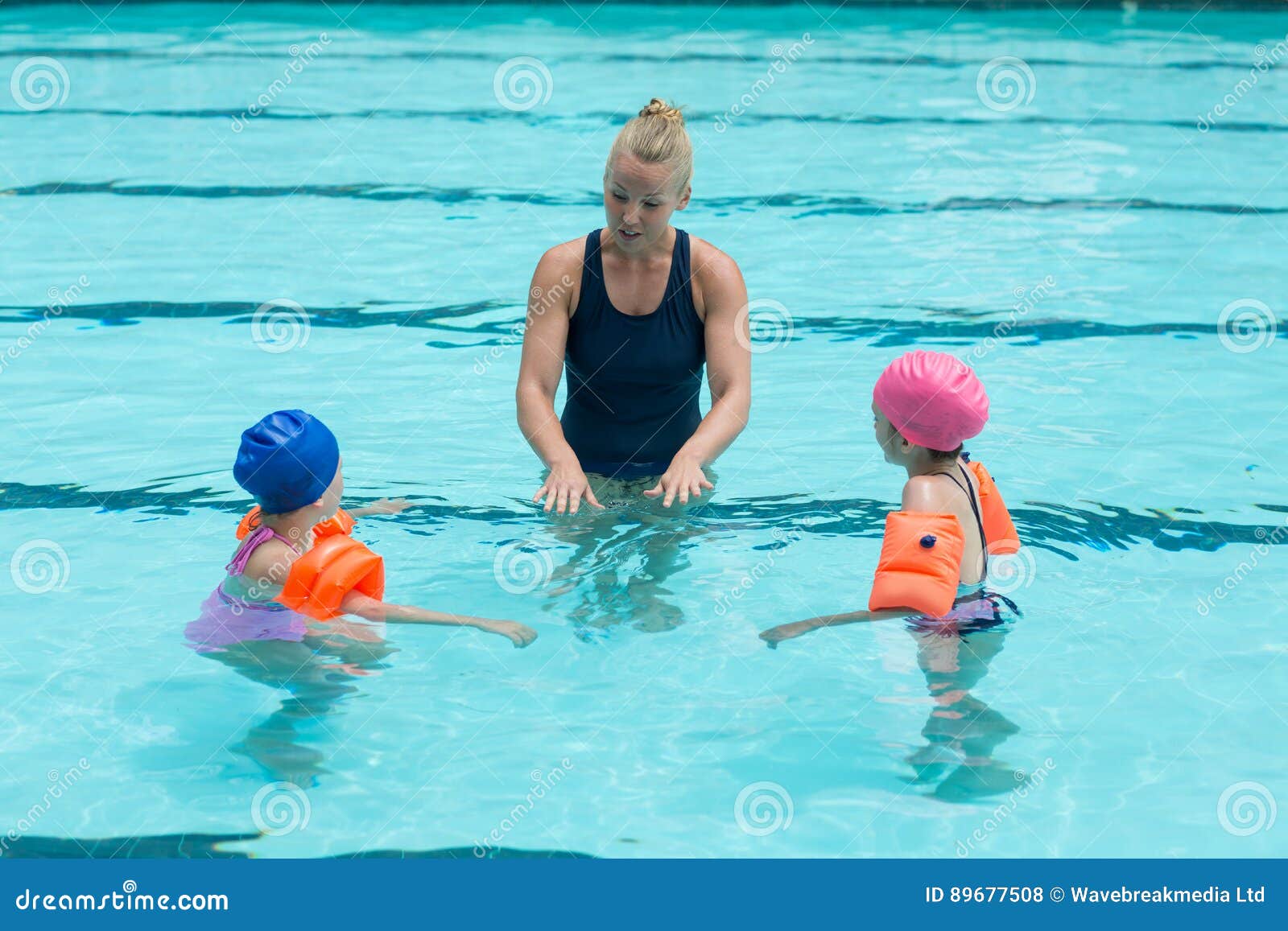 Female Instructor Assisting Children in Swimming Pool Stock Photo ...