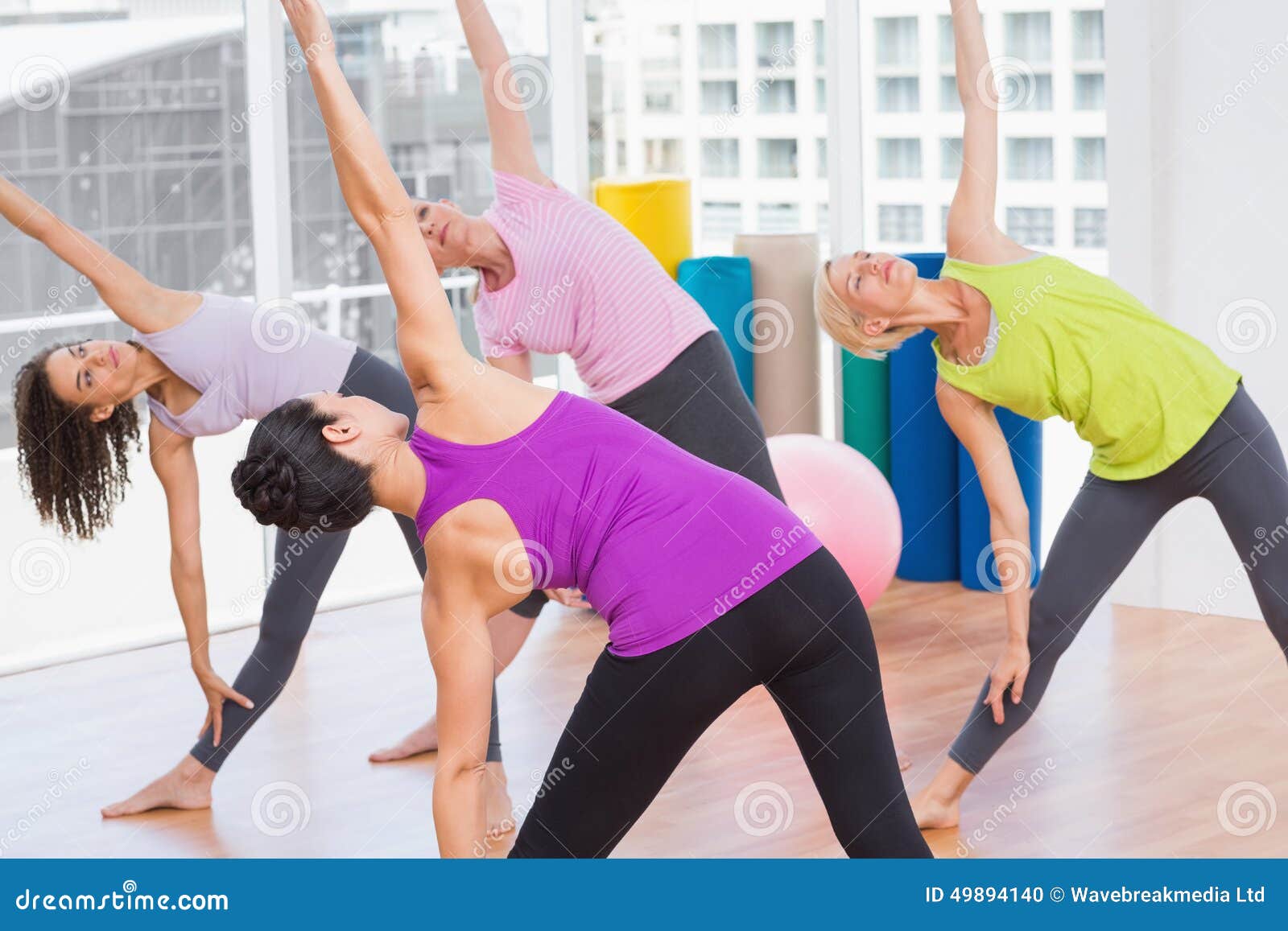 Female Instructor Guiding Friends in Stretching Exercise Stock Photo ...