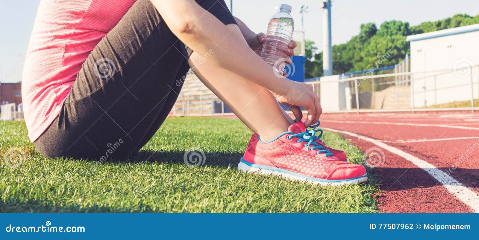 Female Jogger Sitting on the Side of a Stadium Track Stock Photo ...