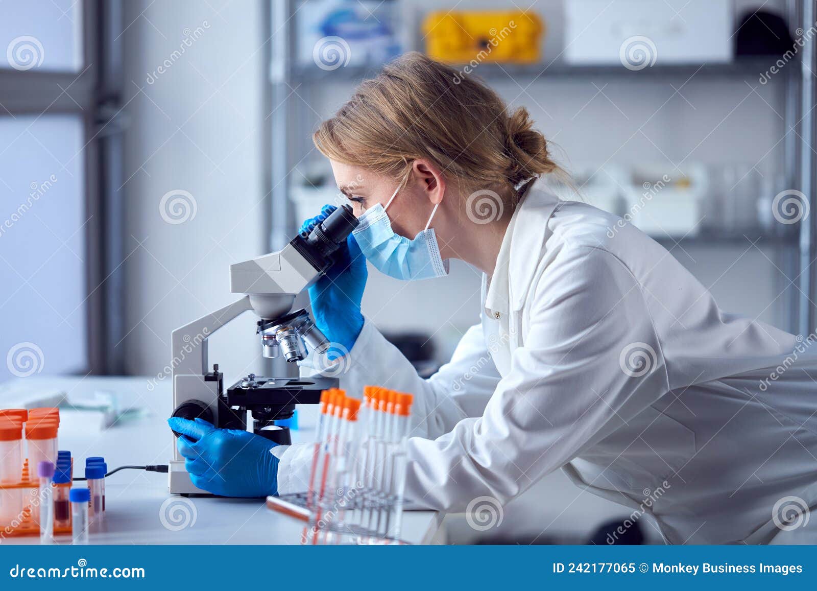 Female Lab Worker Wearing PPE and Safety Glasses Looking at Slide Under ...