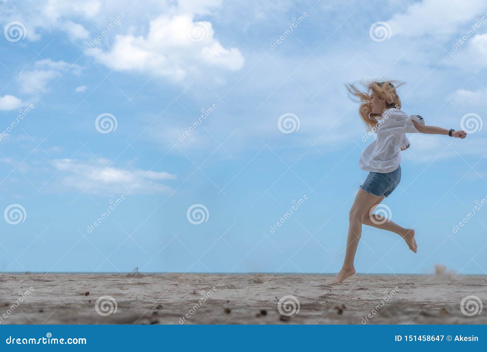 Female Making Jump on Sandy Beach with Blue Sky Stock Image - Image of ...