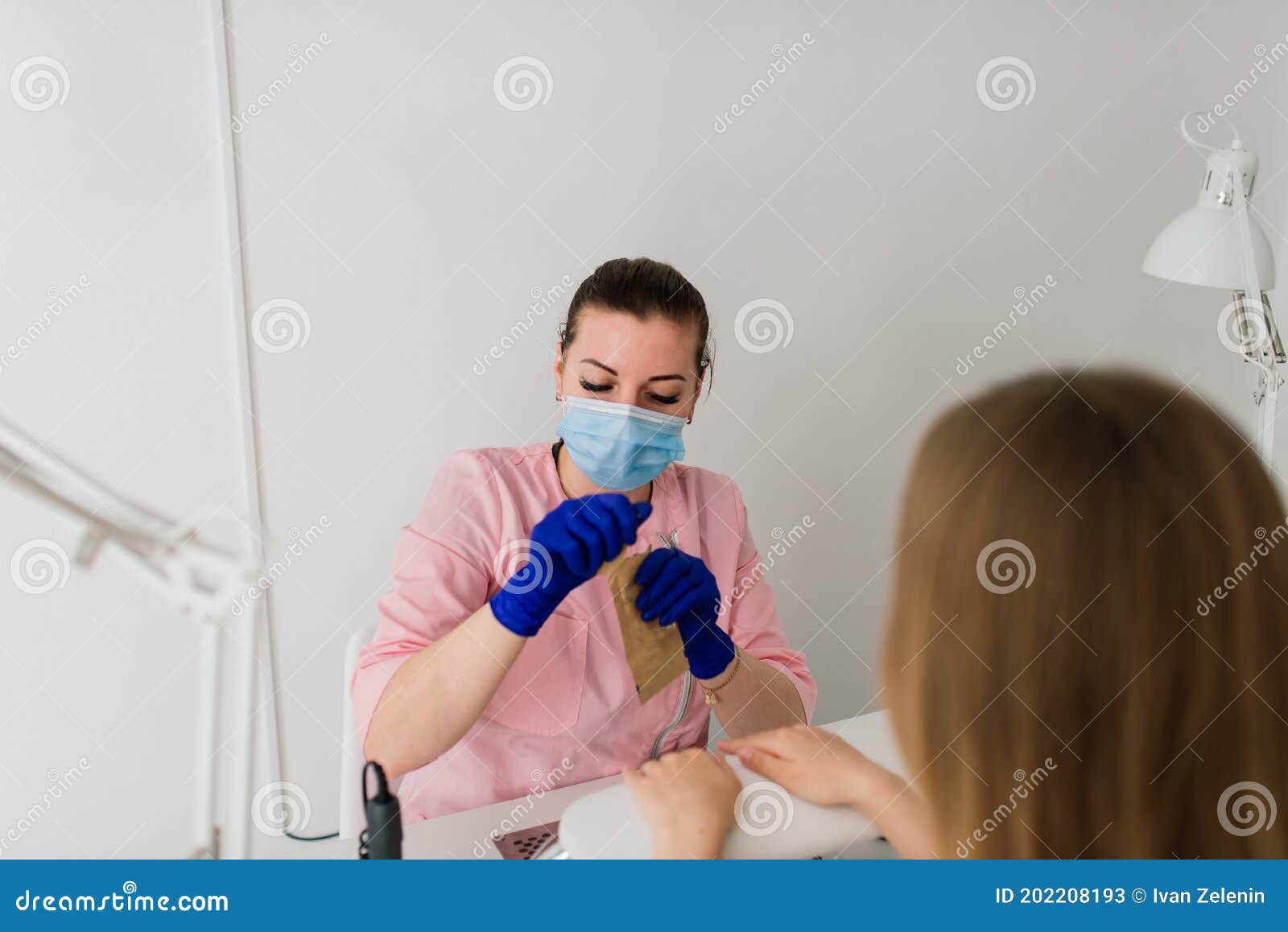 Female Manicure Master in a Beauty Salon Work with Hands of the Client ...