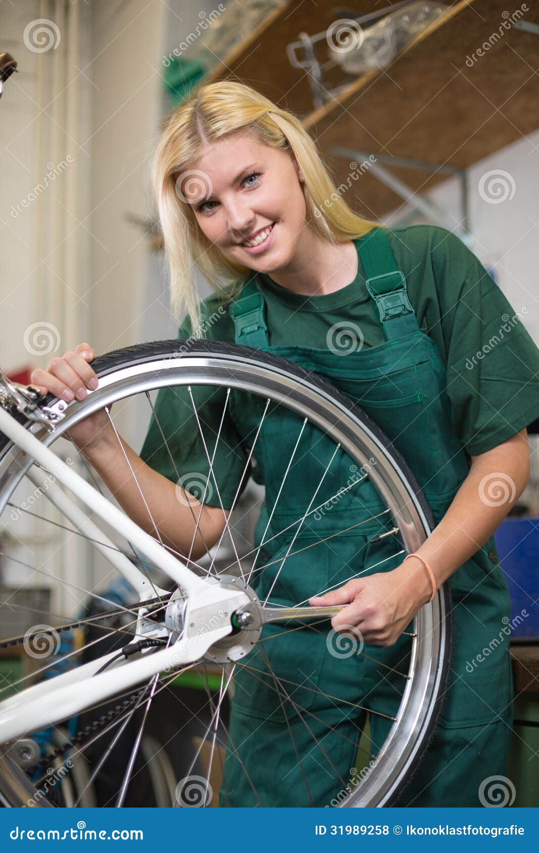 Female Mechanic in Workshop Repairing a Bicycle Wheel Stock Photo ...