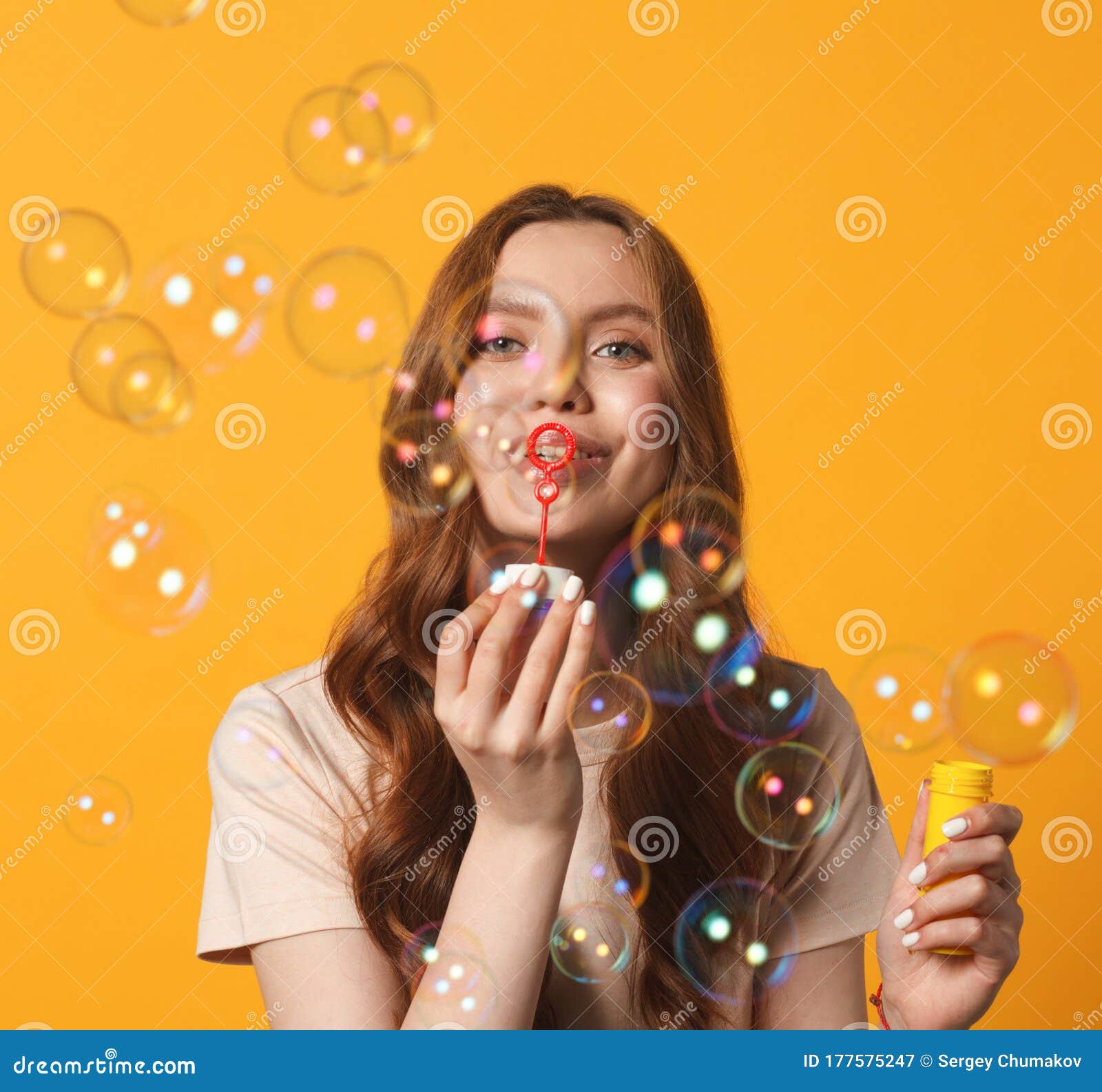 Female Model Blowing Soap Bubbles on Yellow Background, Front View Shot ...