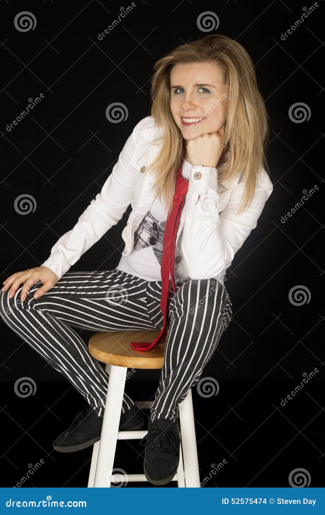 Female Model Sitting on Stool Wearing Striped Pants Smiling Stock Photo ...
