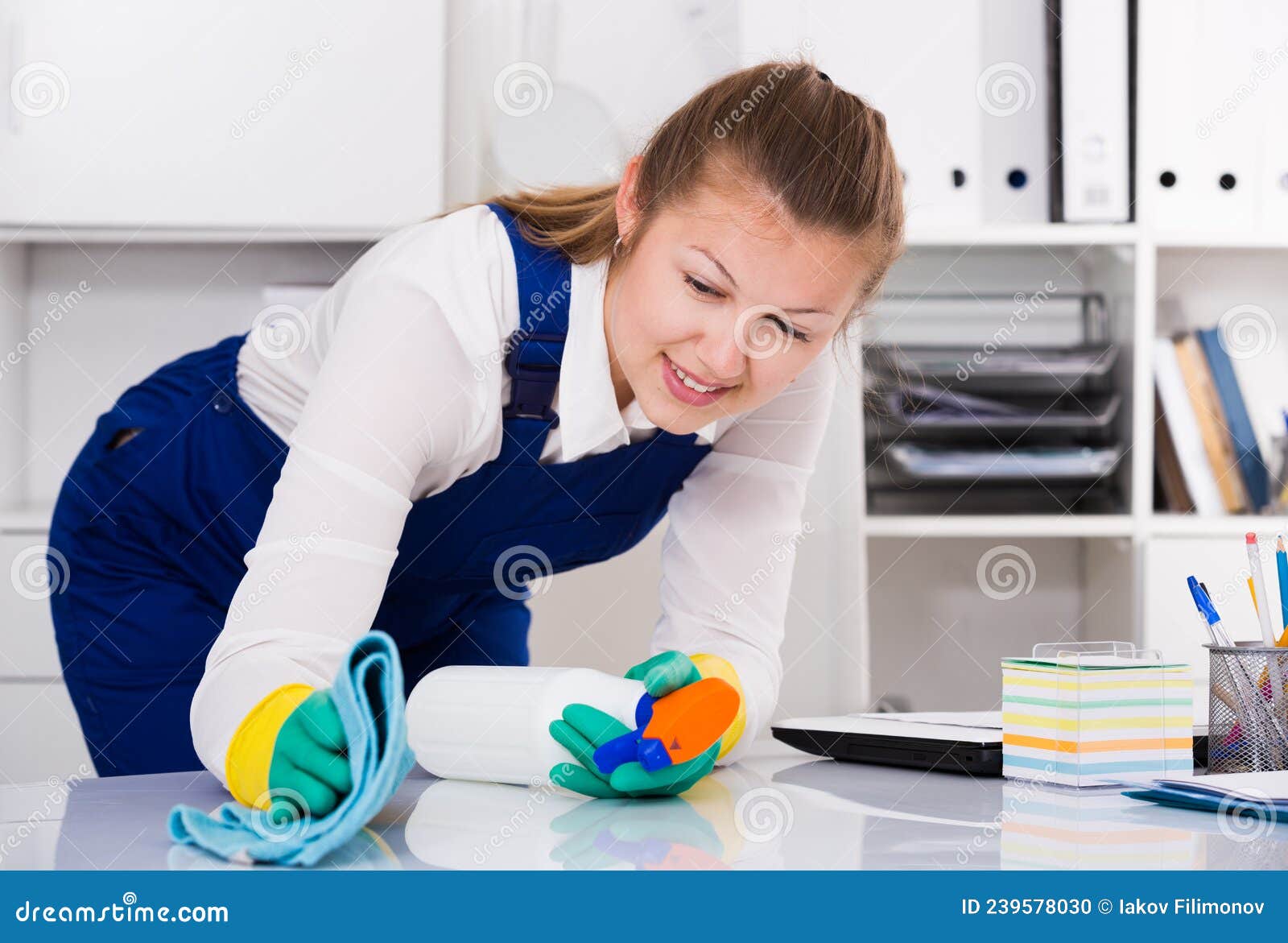 Female Office Cleaner is Cleaning Dust from the Desk Stock Photo ...
