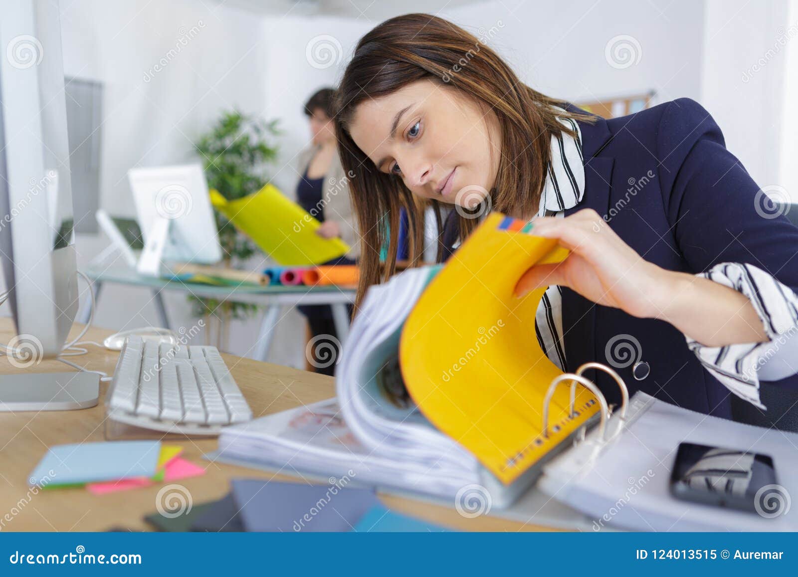 Female Office Worker Flicking through Paperwork in Folder Stock Image ...