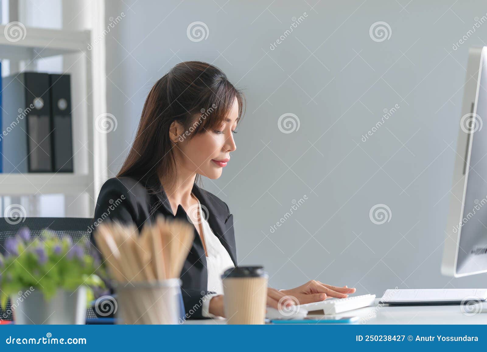Female Office Worker Typing on Keyboard while Working in Front of the ...