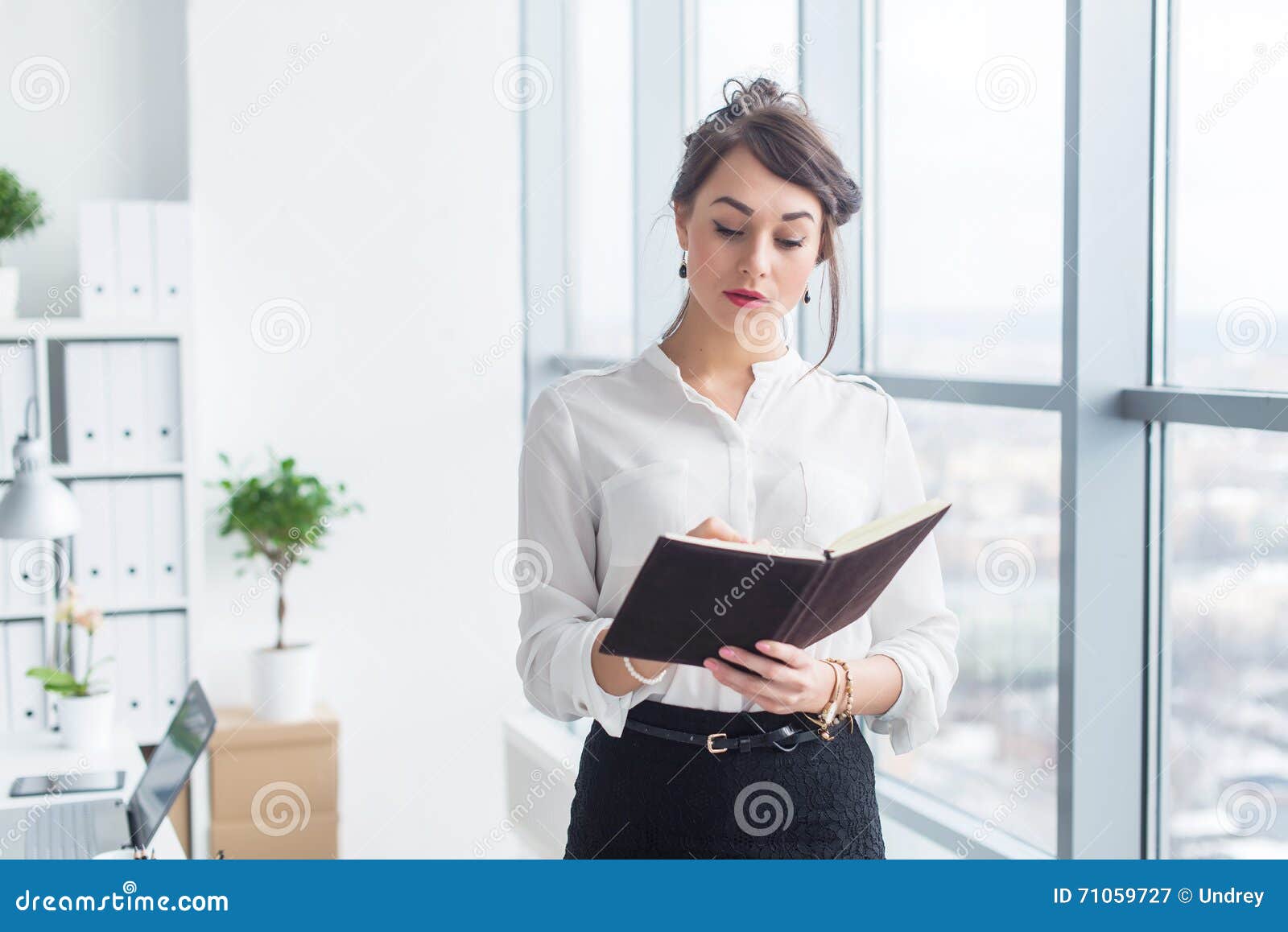 Female Office Worker Writing Down Notes and Day Plan in Her Notebook ...