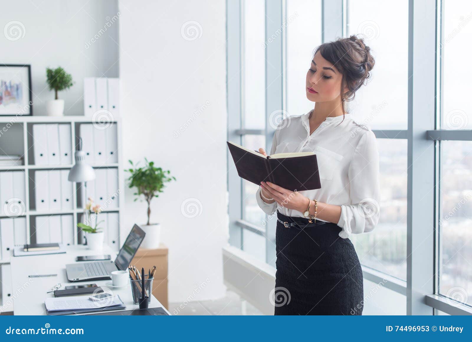 Female Office Worker Writing Down Notes and Day Plan in Her Notebook ...