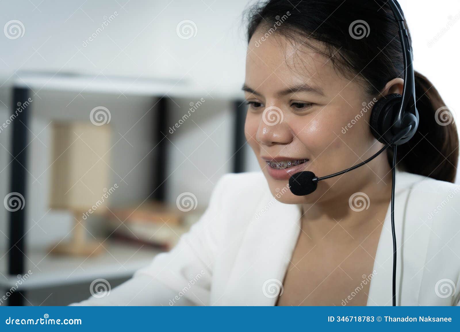 Female Operator Wearing a Headset is Talking on the Phone. she is ...