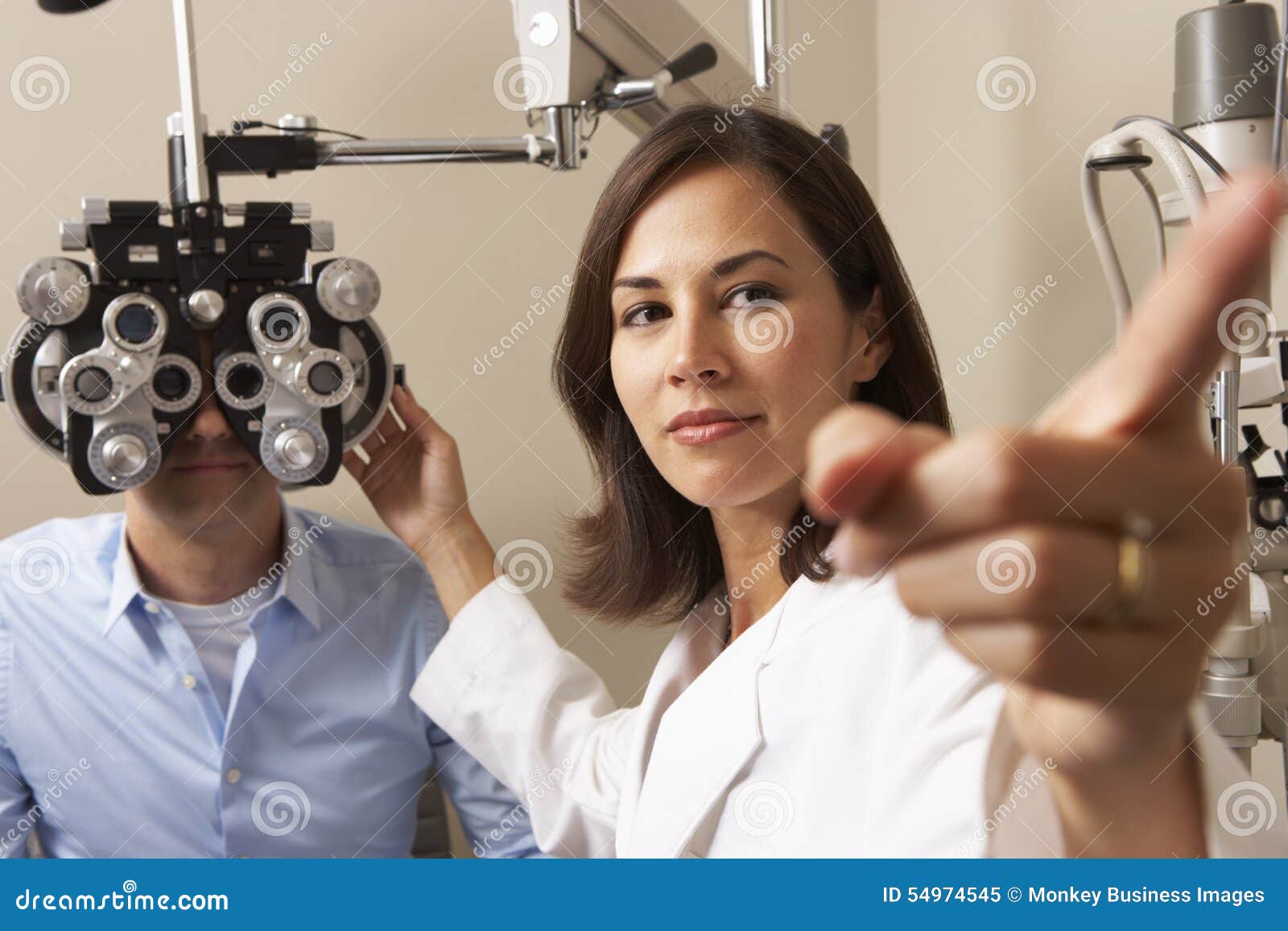 Female Optician in Surgery Giving Man Eye Test Stock Image - Image of ...