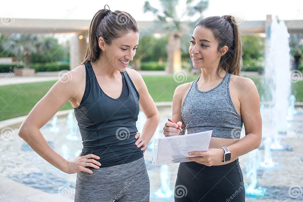 Female Personal Trainer Checking Progress of Her Client after Exercise ...