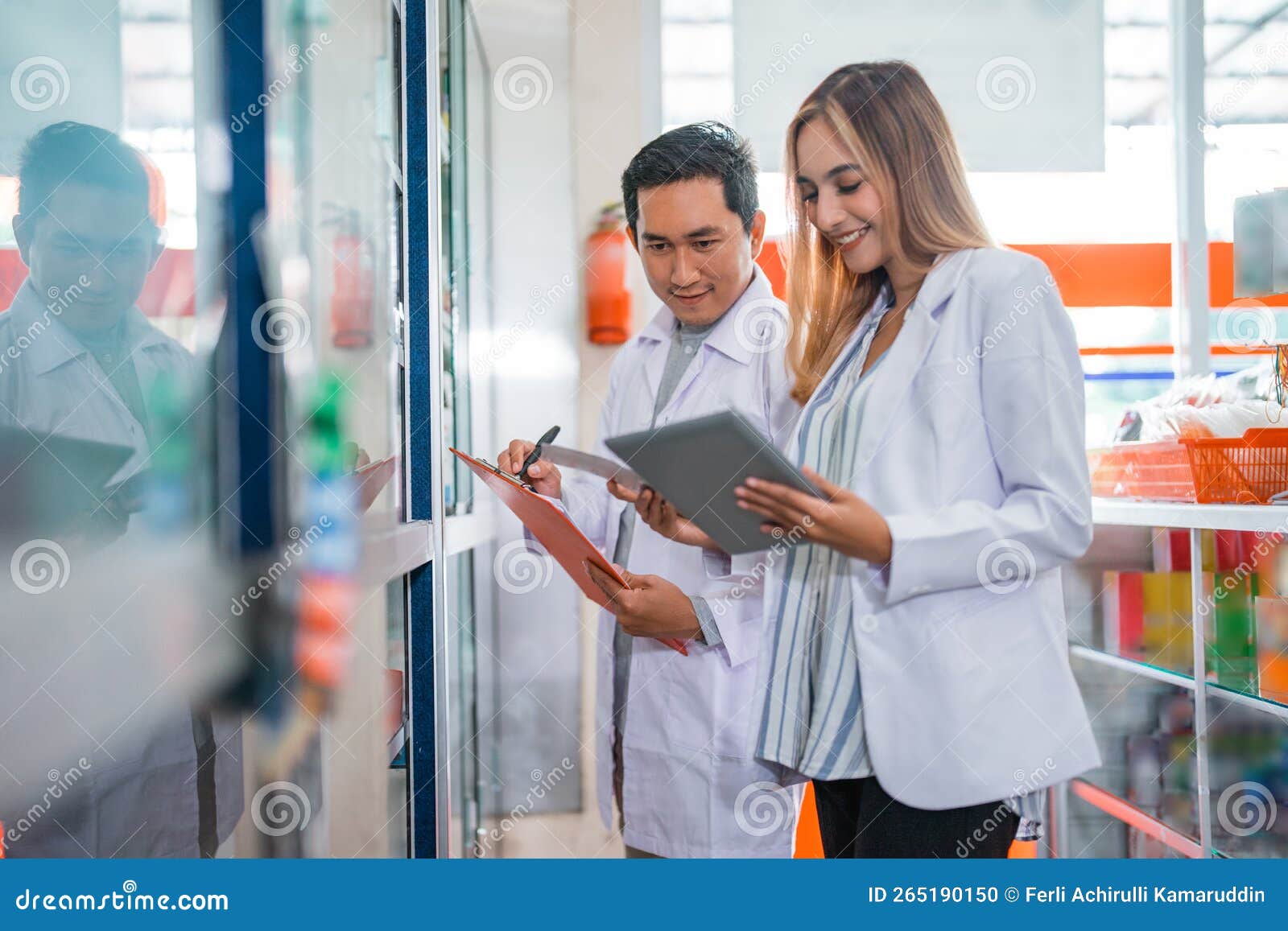 Female Pharmacist in Uniform Using Tablet while Checking with Friends ...