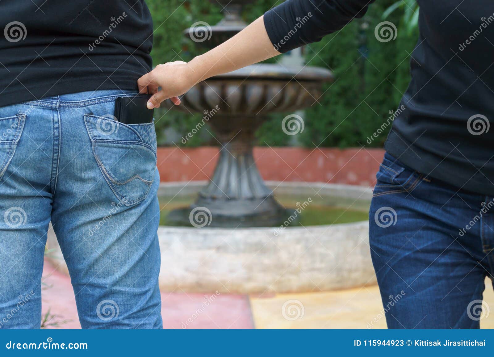 Female Pickpocket Stealing A Wallet From Behind Pocket On Jeans Stock