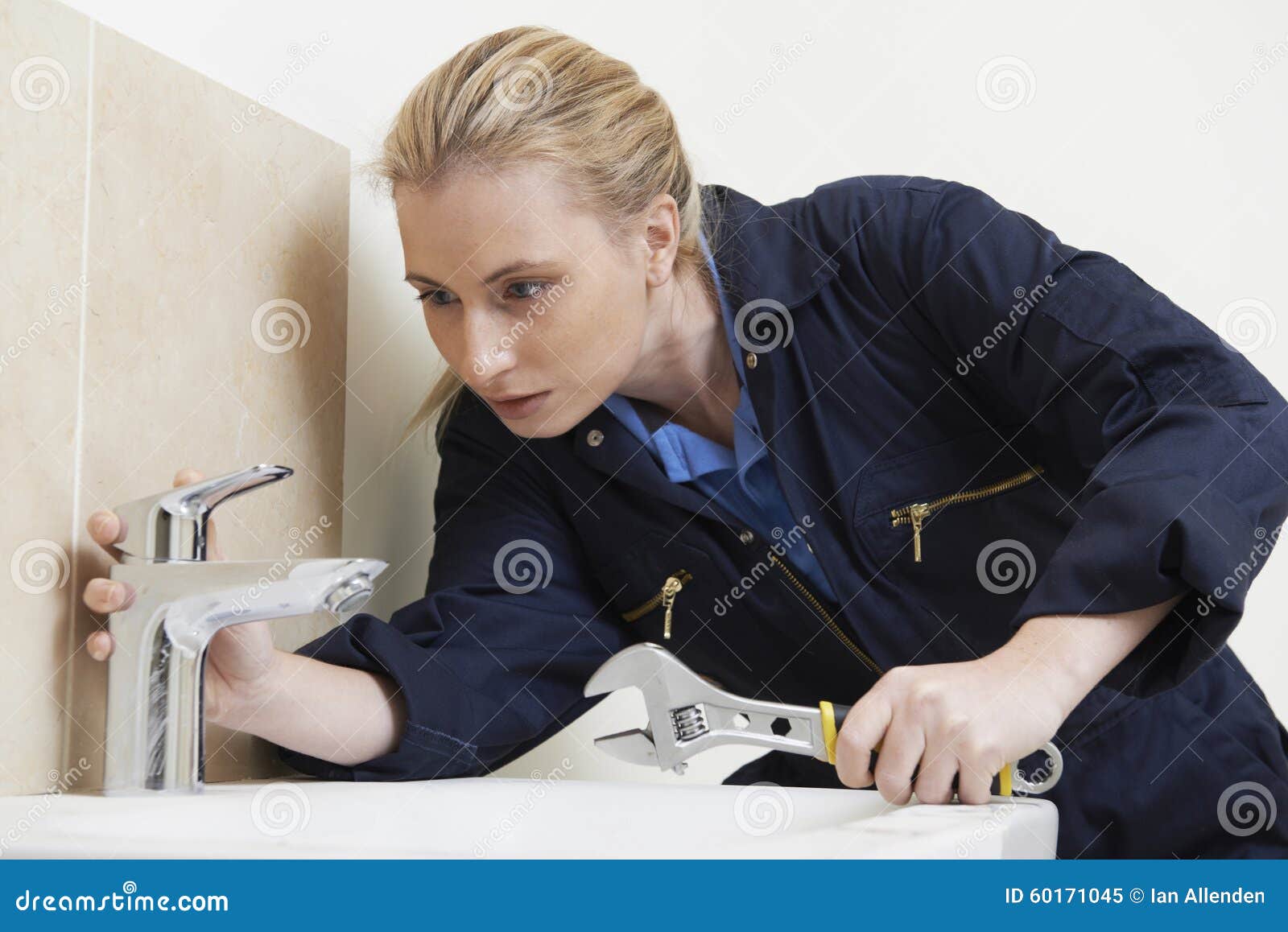 Female Plumber Working on Sink Using Wrench Stock Image - Image of ...