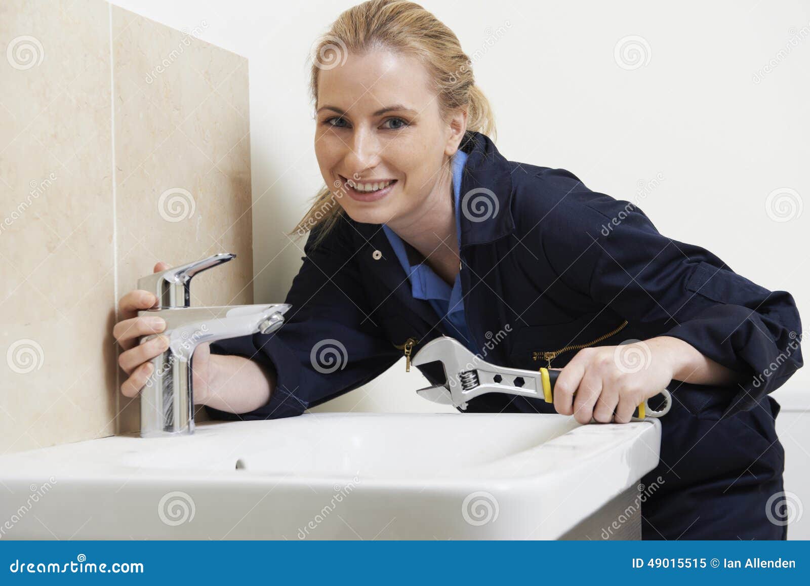 Female Plumber Working On Sink Using Wrench Stock Photo - Image: 49015515