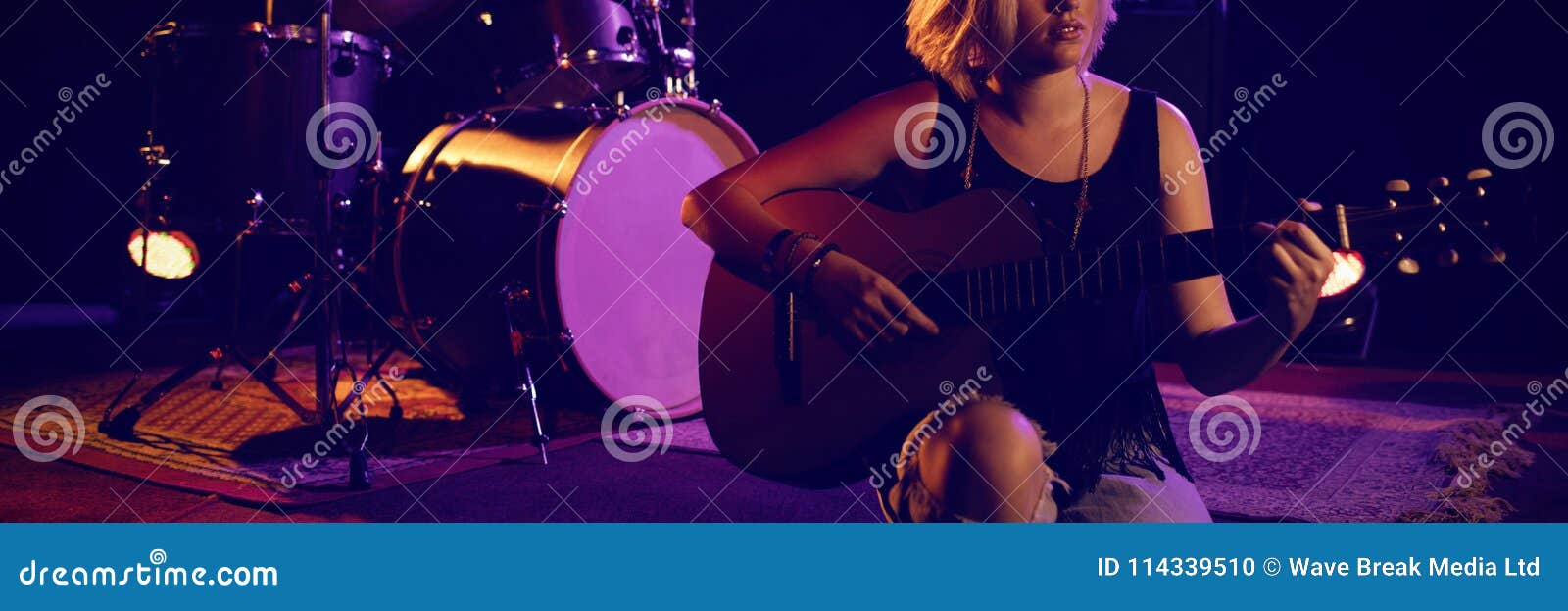 Female Practicing Guitar while Sitting on Stage Stock Photo - Image of ...