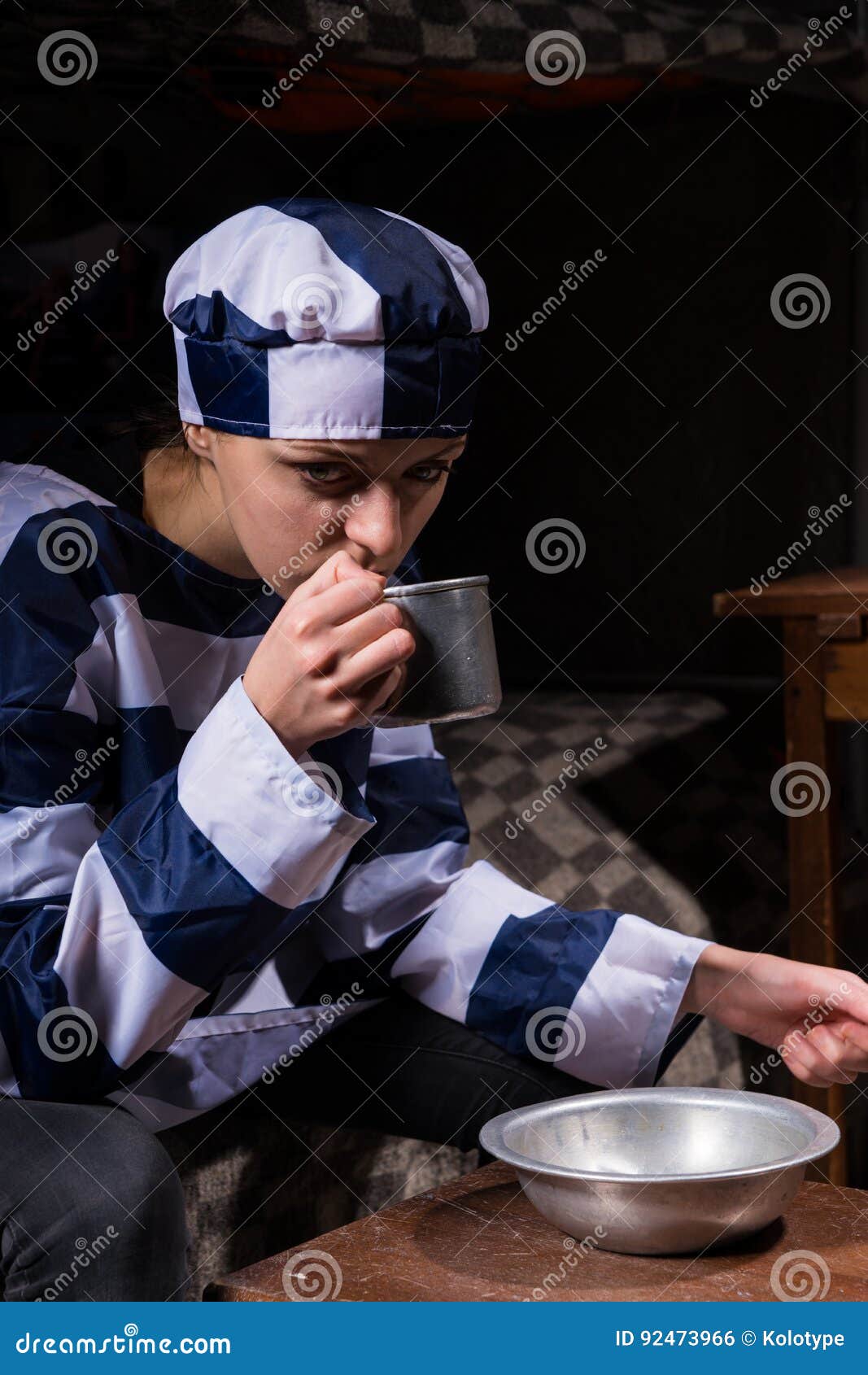 Female Prisoner Drinking from an Aluminum Cup in a Small Prison Stock ...