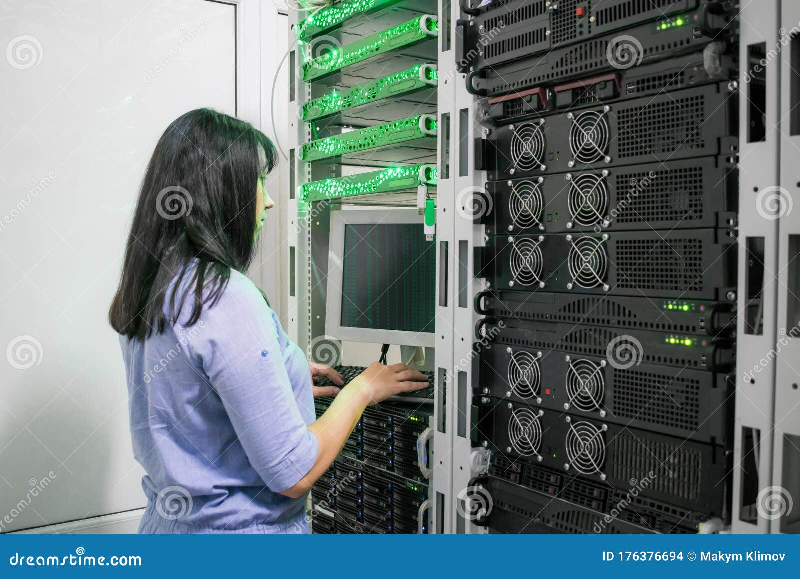 A Female Programmer is Working in a Server Room. the Girl is Standing ...