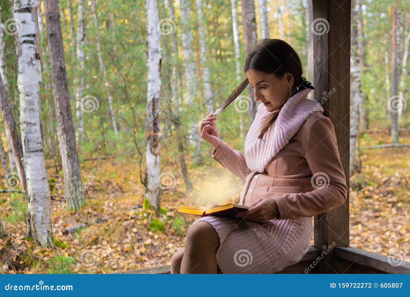 Female Reads a Magic Book in a Forest in the Past. Magical Light Shines ...