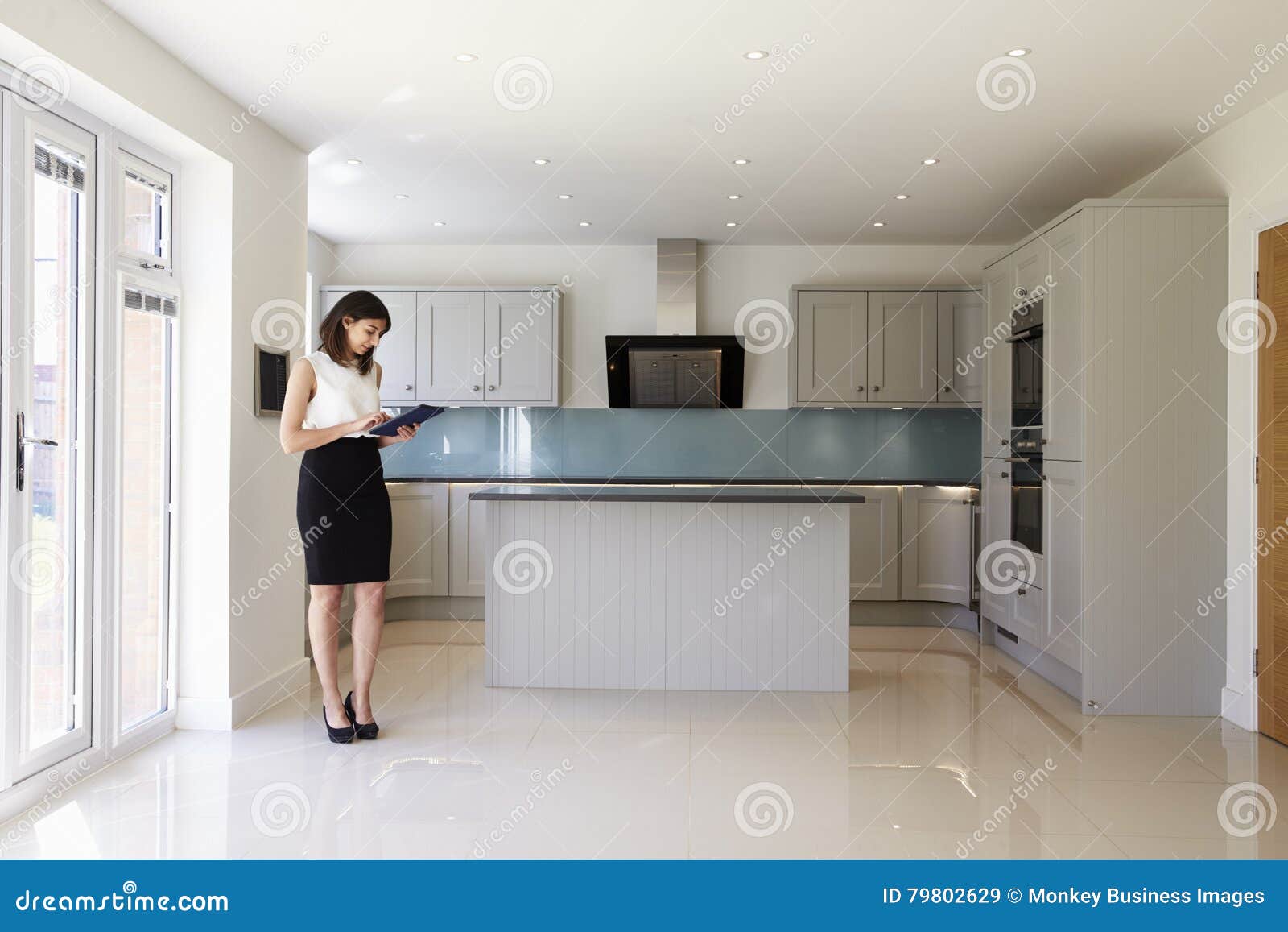 Female Realtor in Kitchen Carrying Out Valuation Stock Image - Image of ...