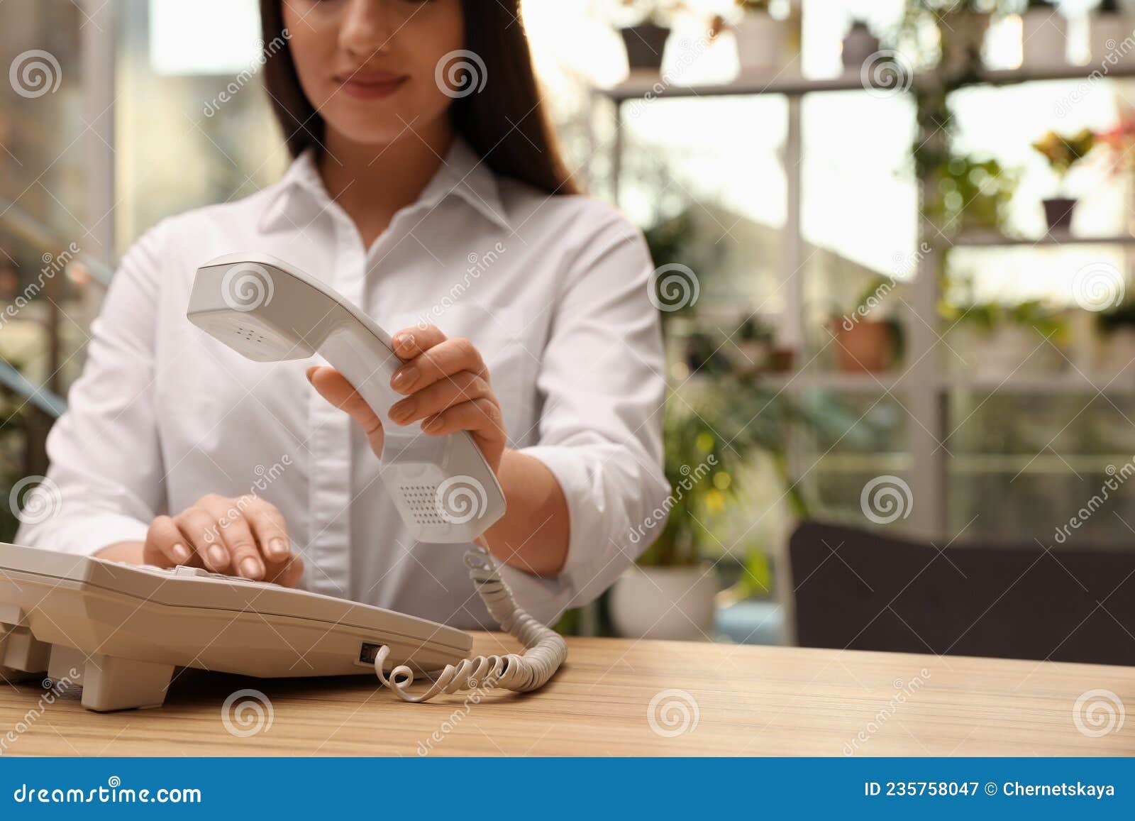 Female Receptionist Picking Up Phone at Workplace, Focus on Hands ...